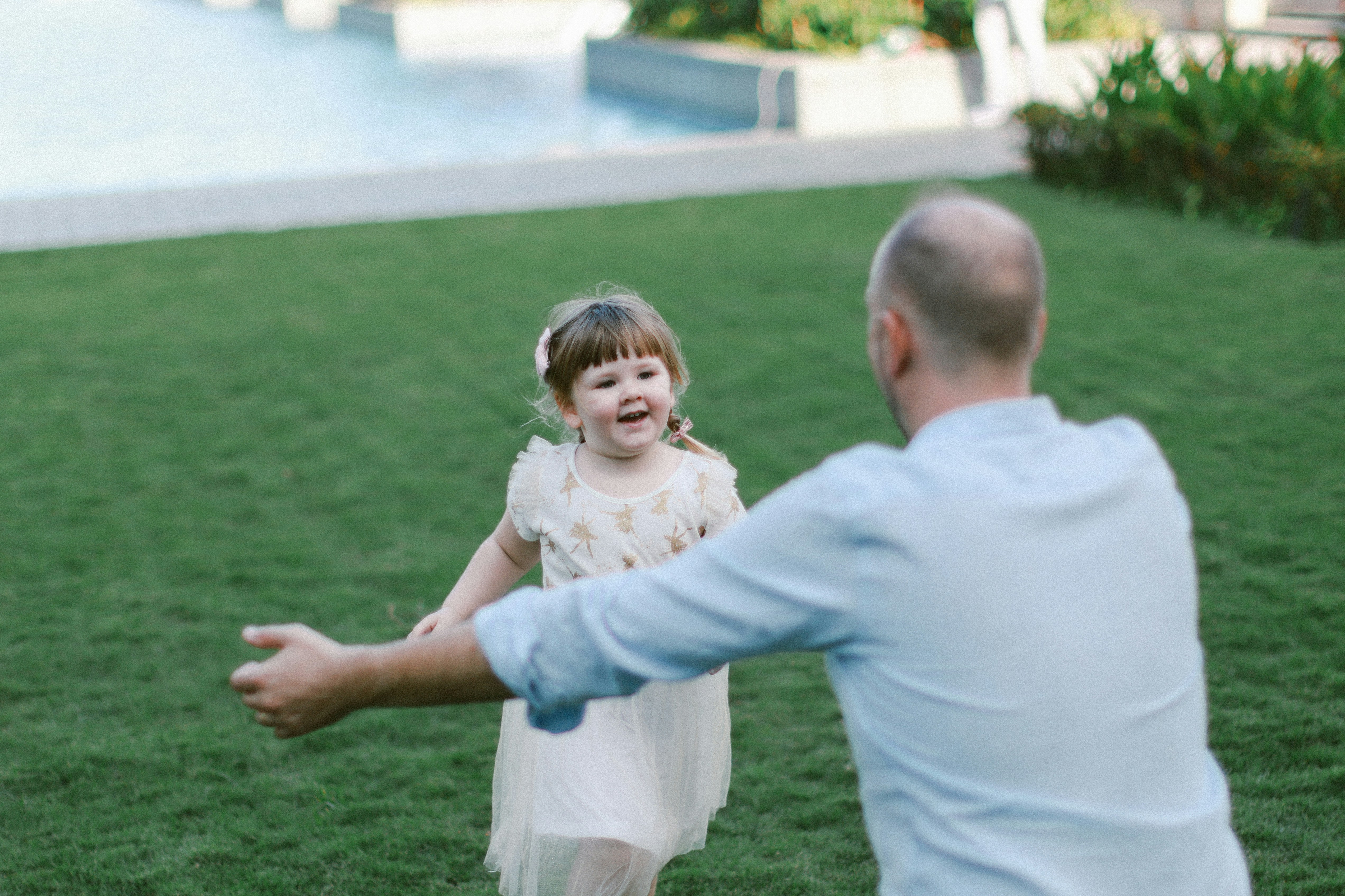 First Snowball of Joy: A Father Spins with His Daughter on the Lawn