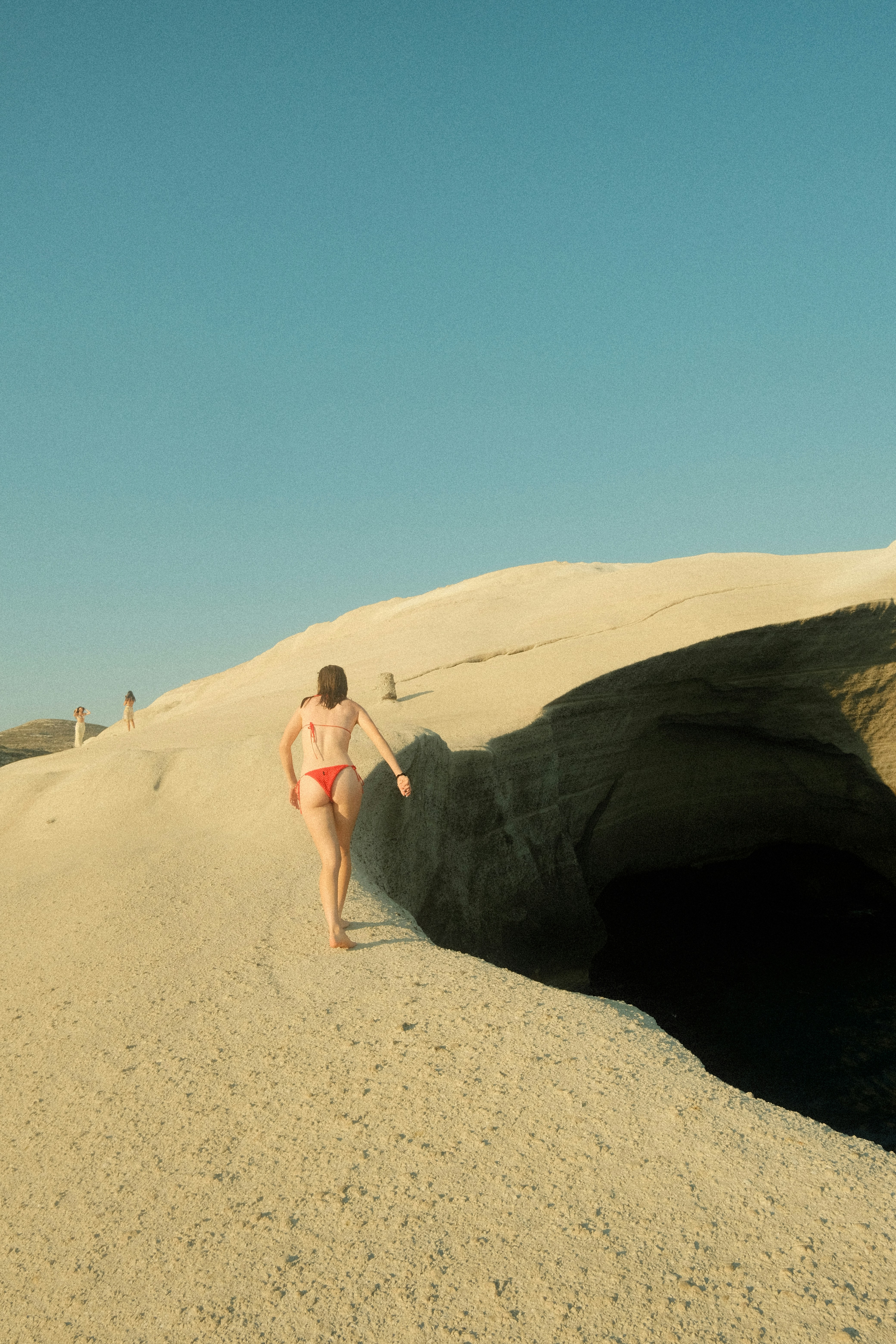 Sunlit Climb: A Silhouette of Resolve on Coastal Sand
