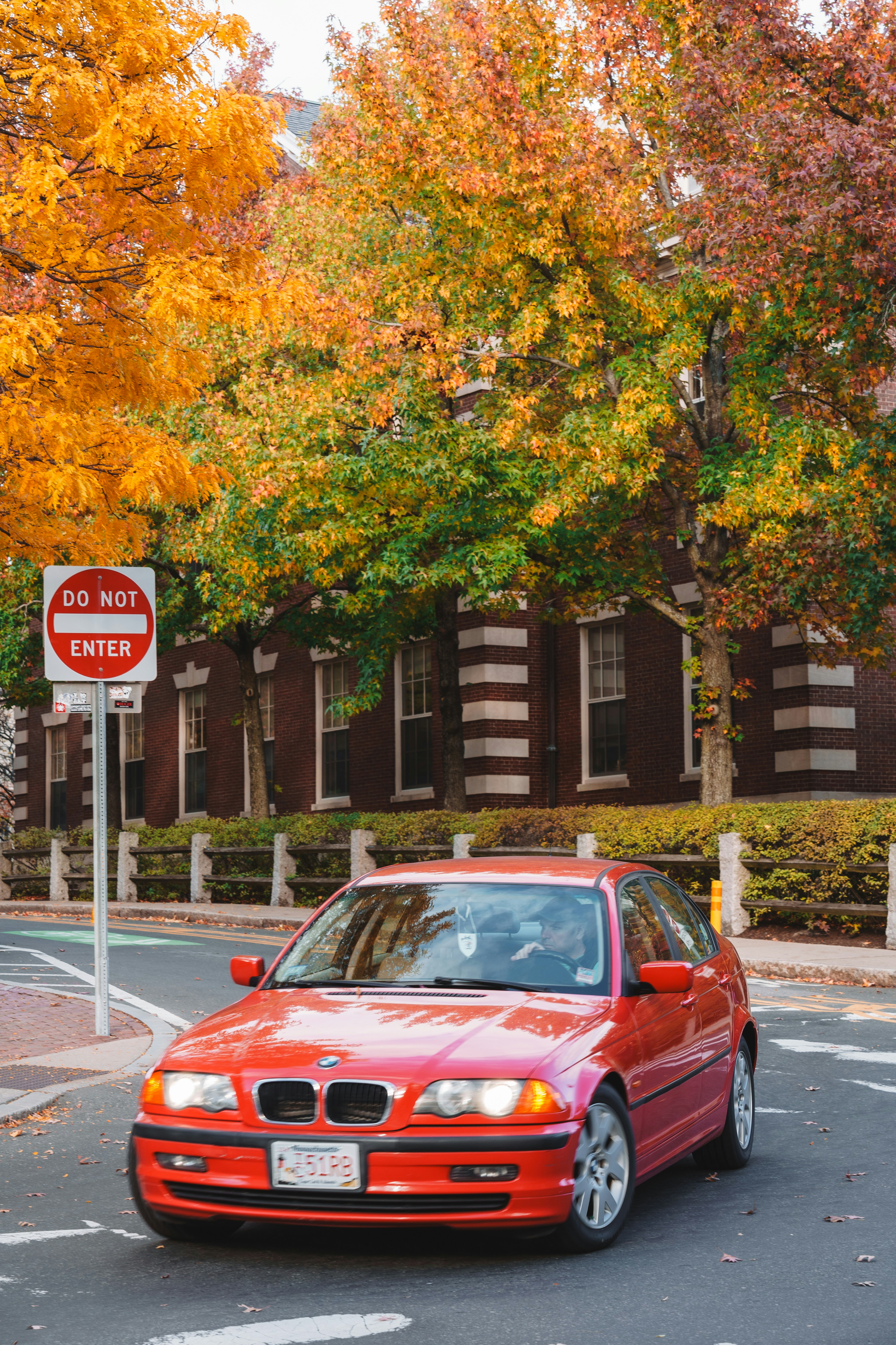 Red Sedan on a Fall Street Corridor