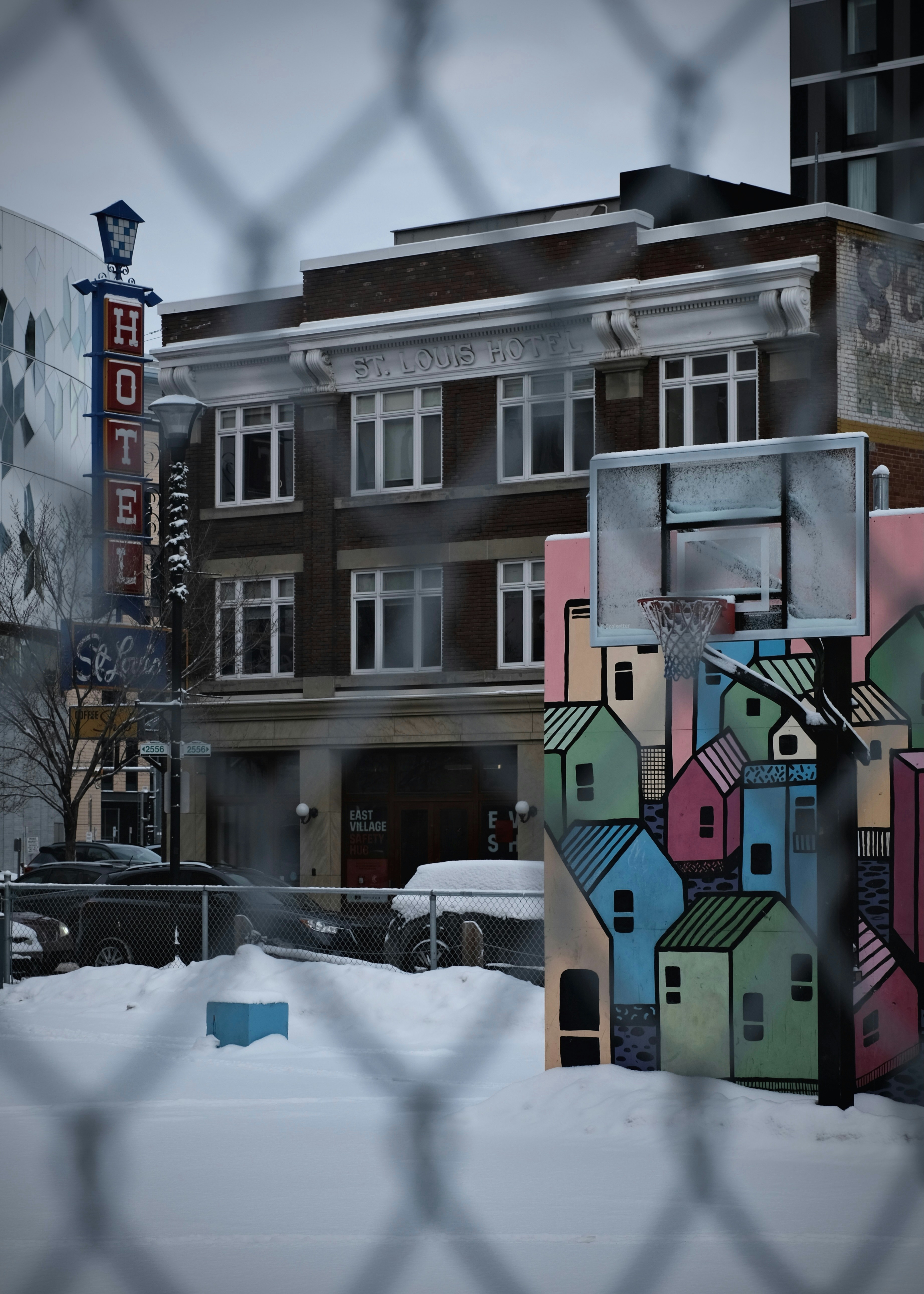 Snowy Court Yard Gallery: A Basketball Hoop Framed by Urban Murals
