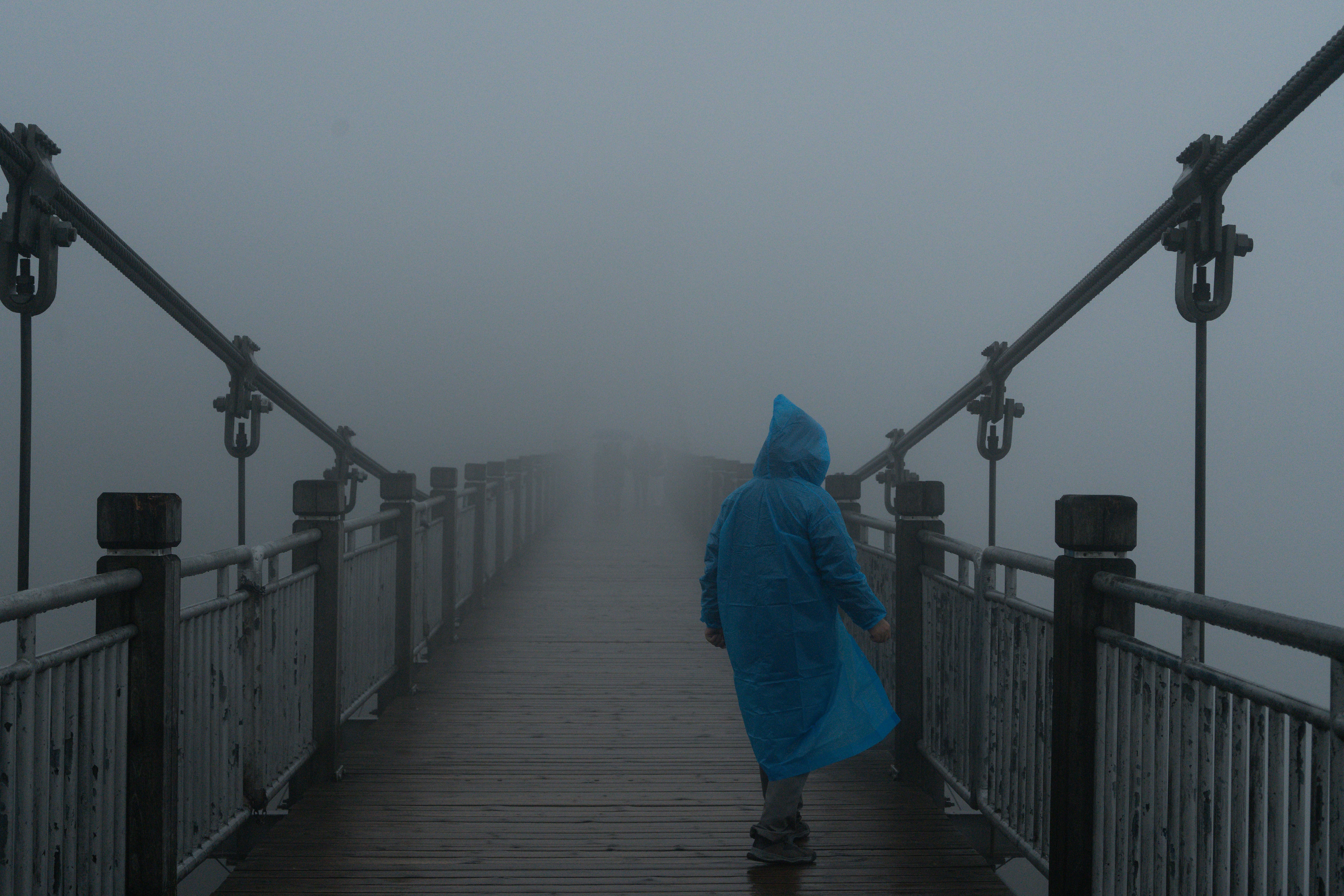 Blue Raincoat on the Fogged Pier