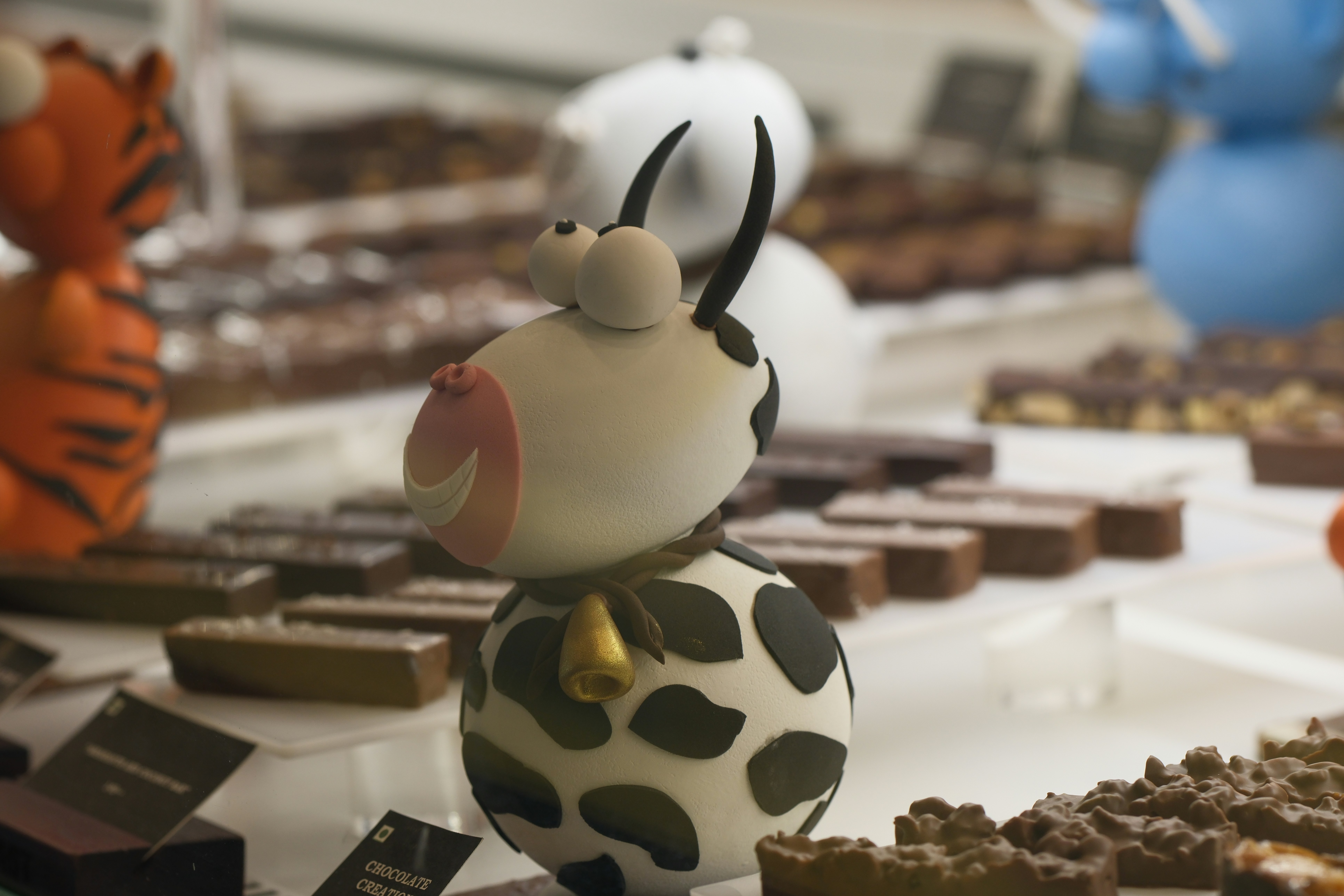 Playful cow-patterned figurine takes center stage among chocolate treats