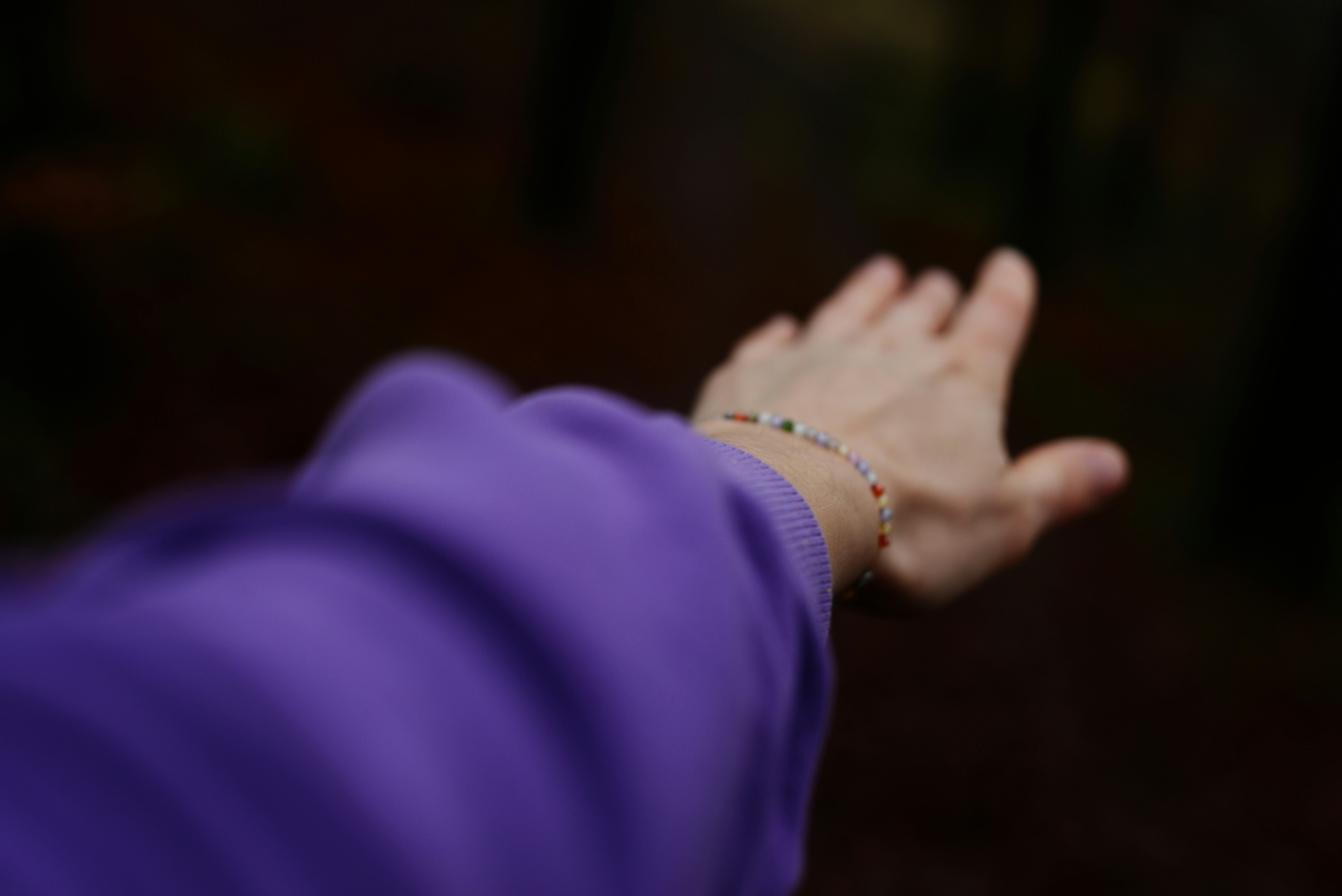 Caught in a Quiet Moment: A Purple Sleeve and Outstretched Hand