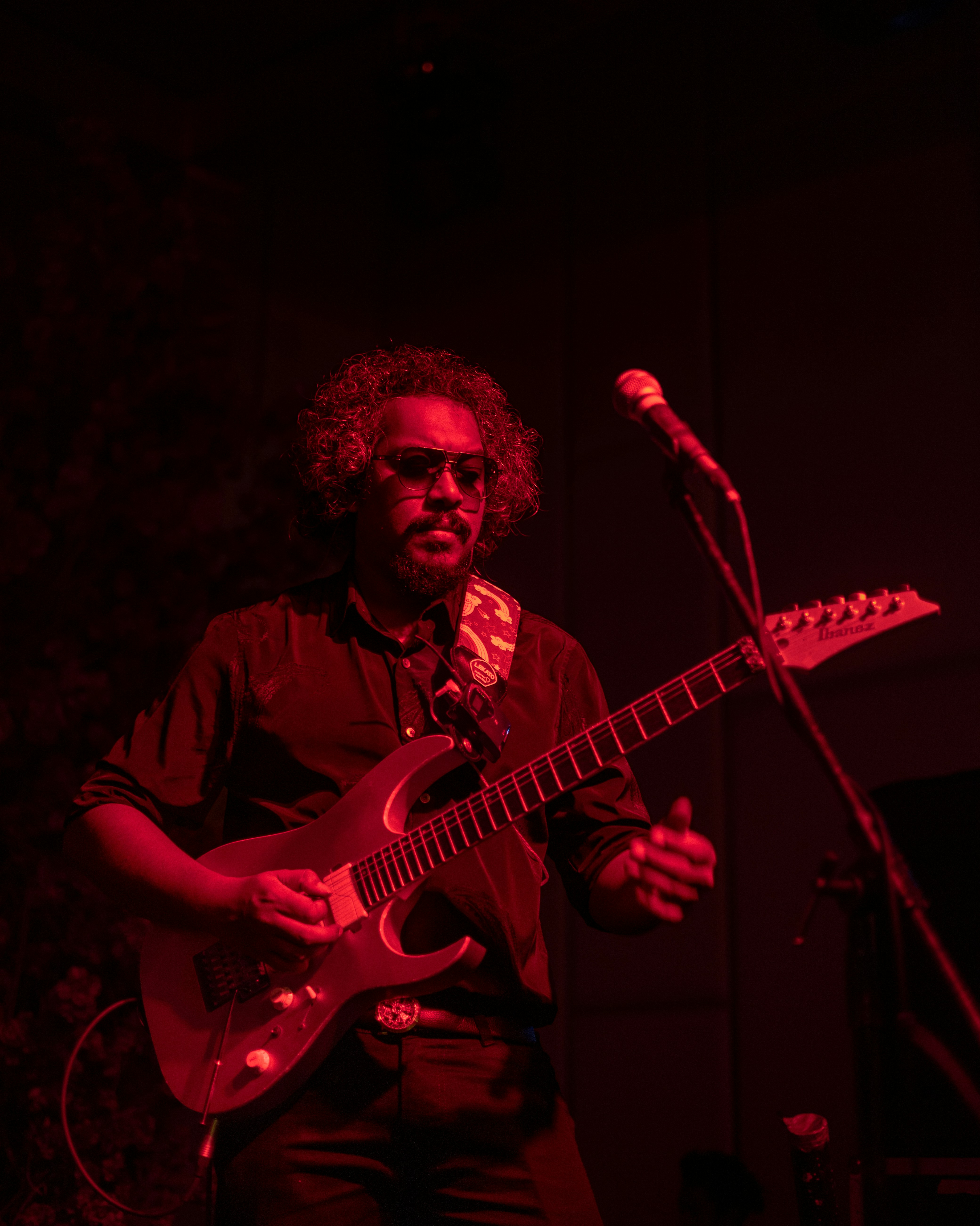 Red-Hued Guitarist Under Stage Lights