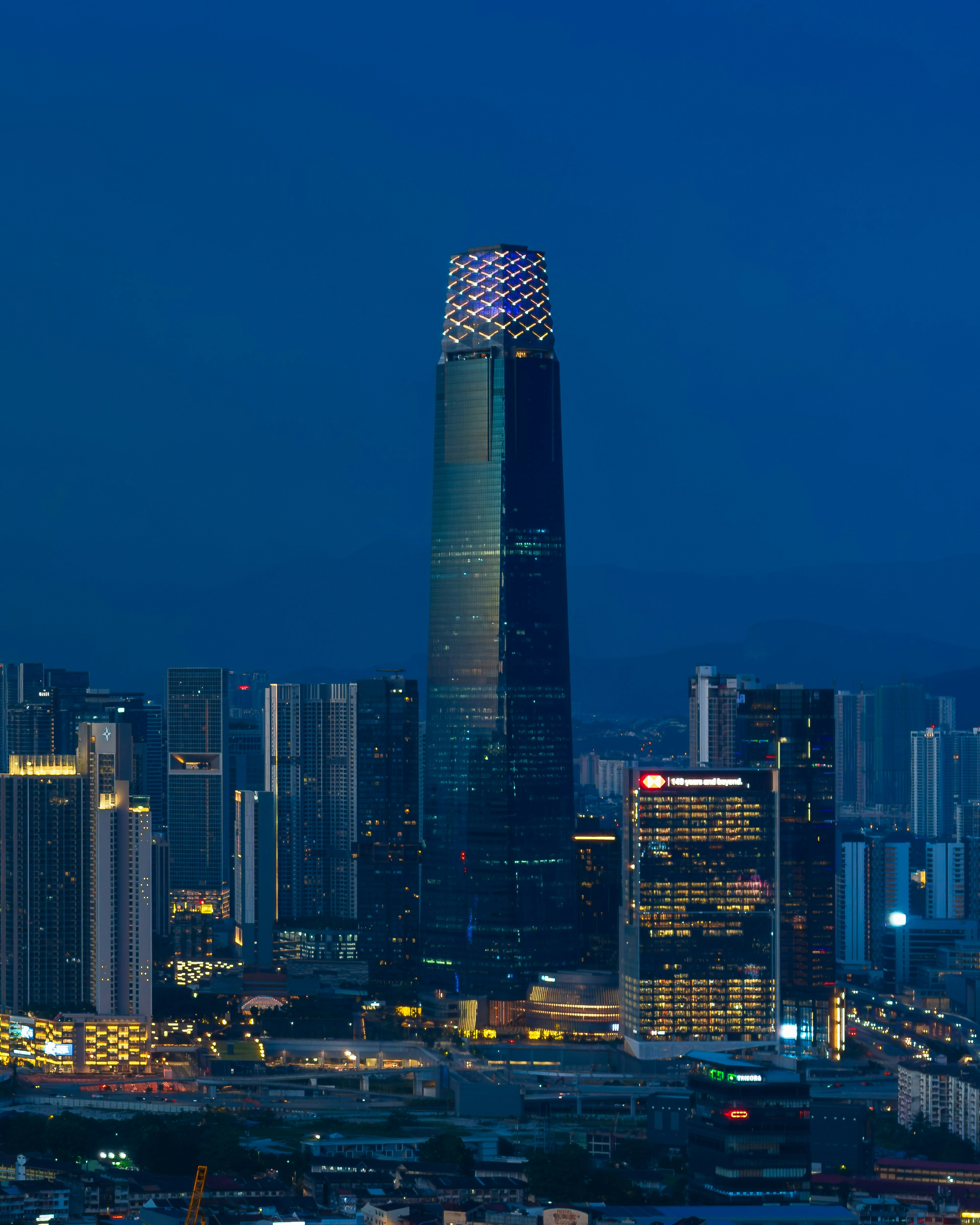 Tall skyscraper illuminated at night with city lights photo – Free ...