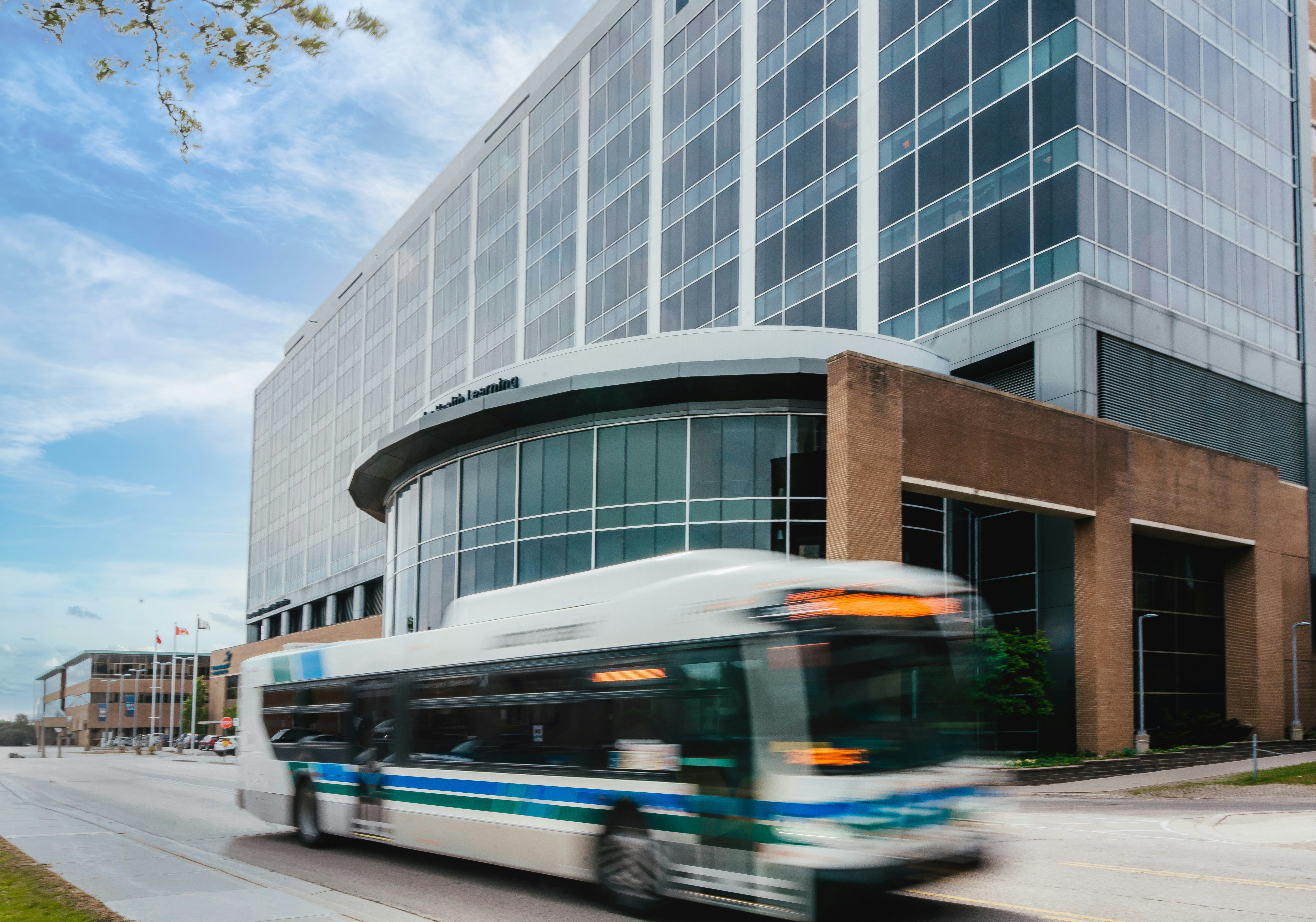 Bus in Motion Before a Modern Glass Facade