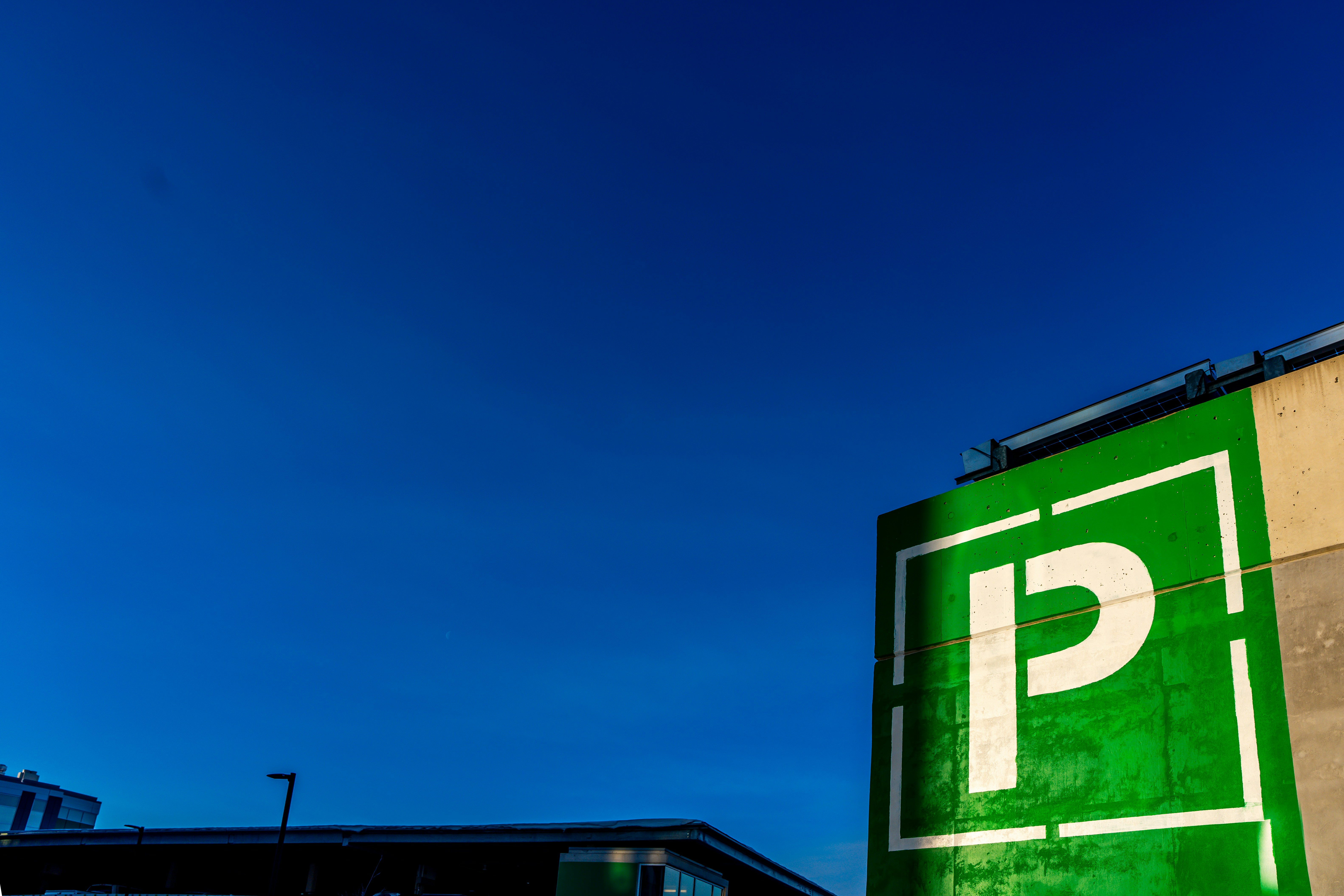 Bright Parking Sign Under a Deep Blue Sky