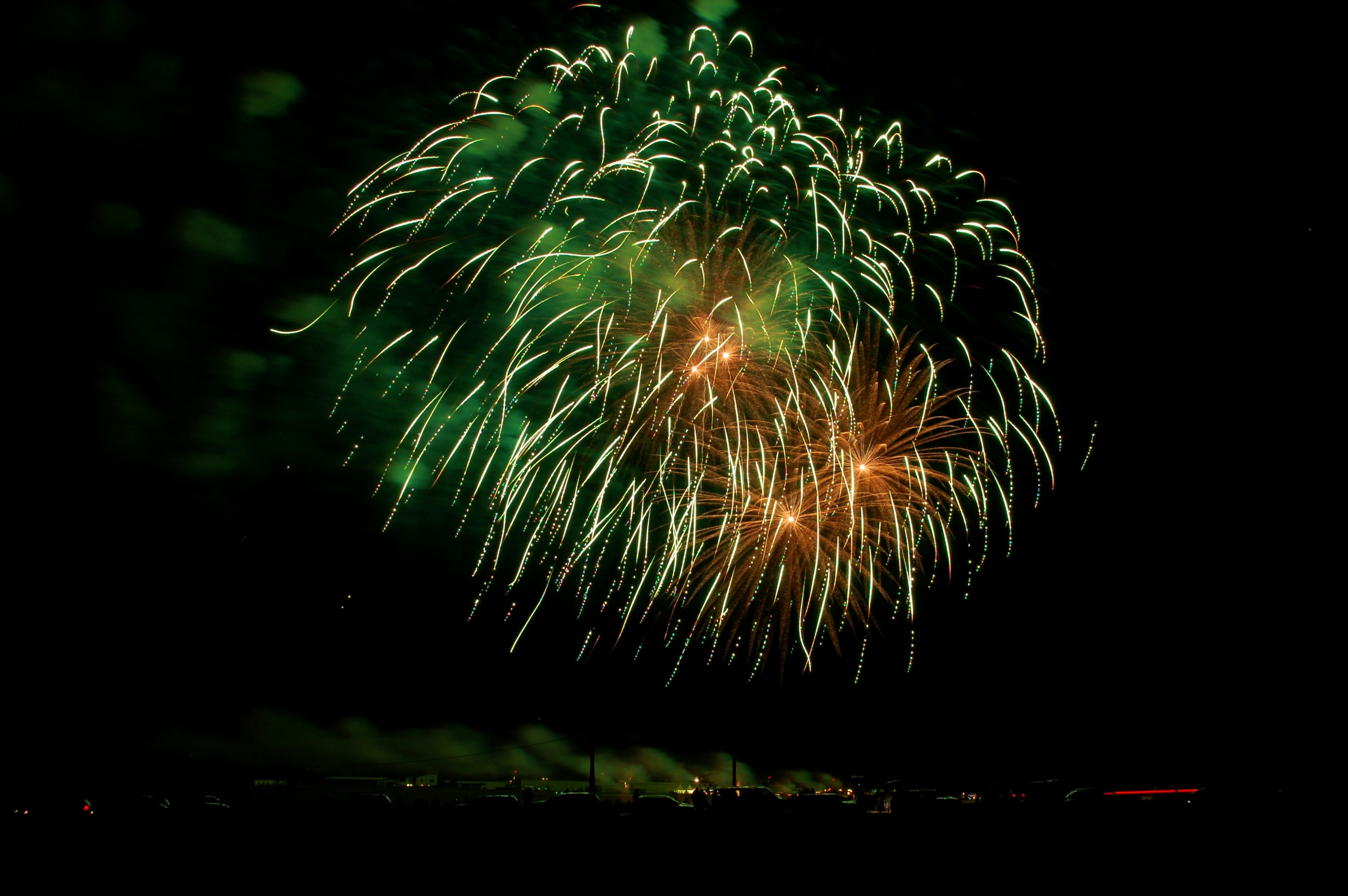 Emerald And Amber Bloom: Fireworks Against a Dark Horizon