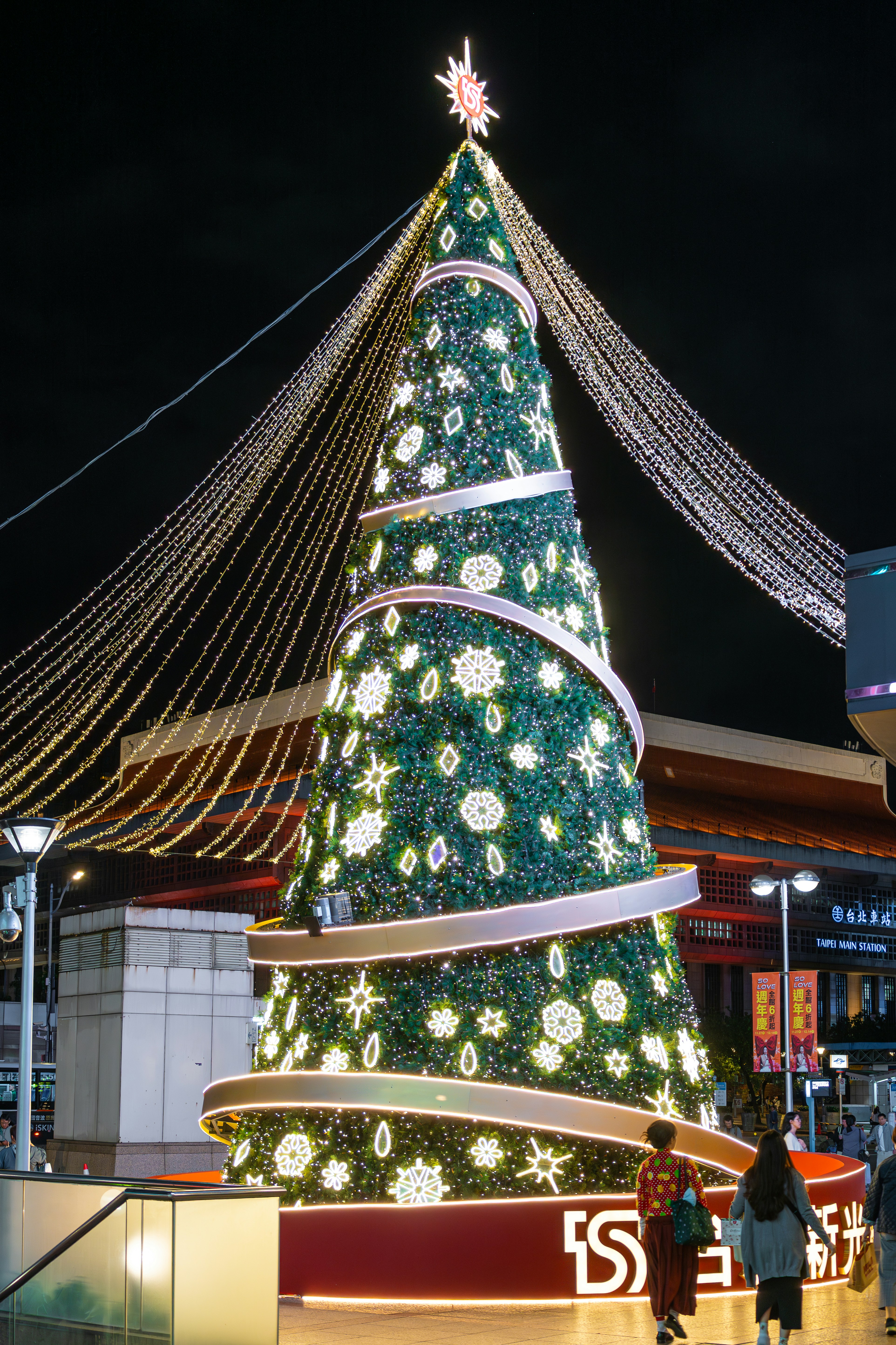 Towering Holiday Lights: A Neon Christmas Spire at Night