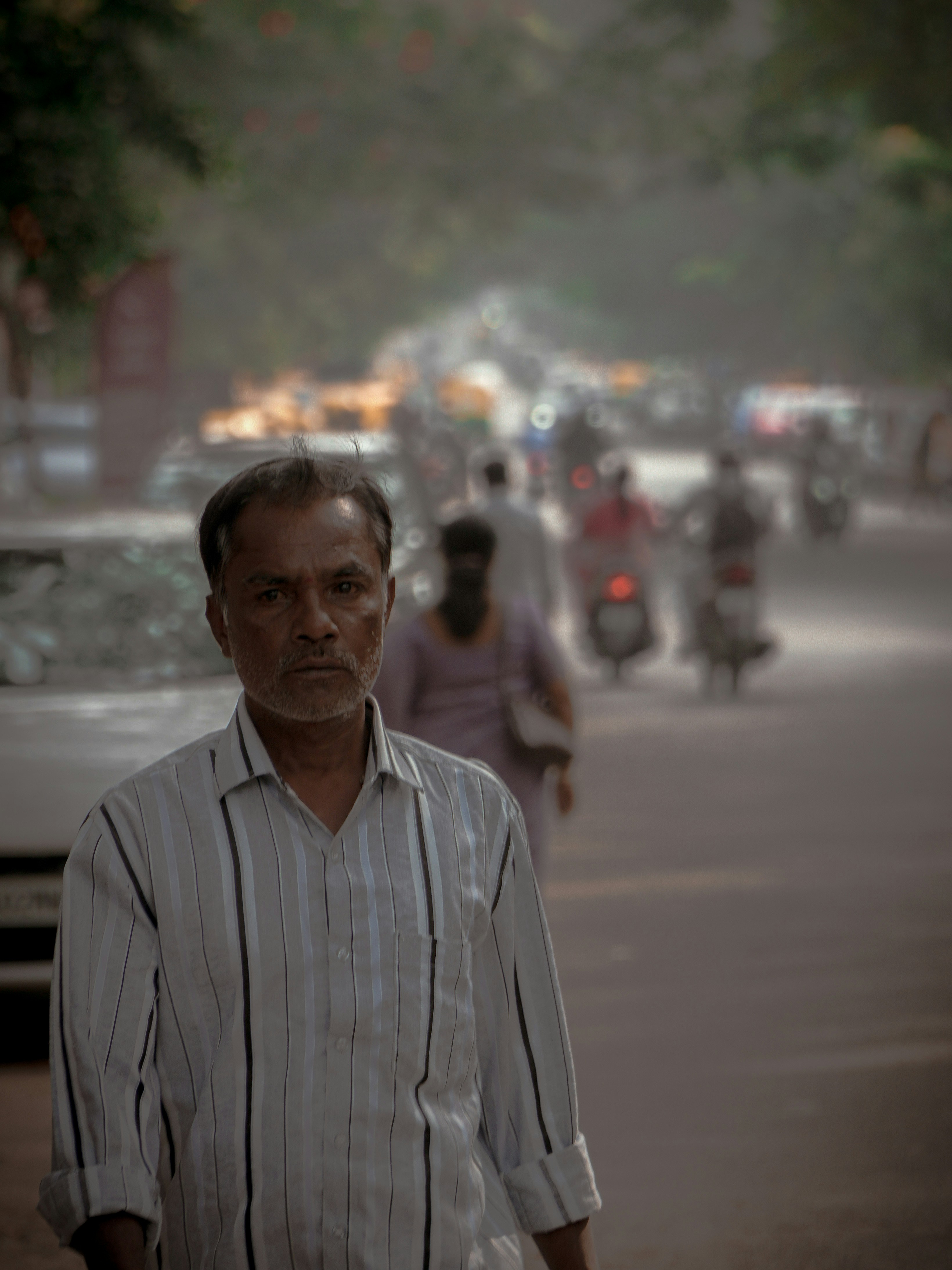 Man in striped shirt at a hazy city street