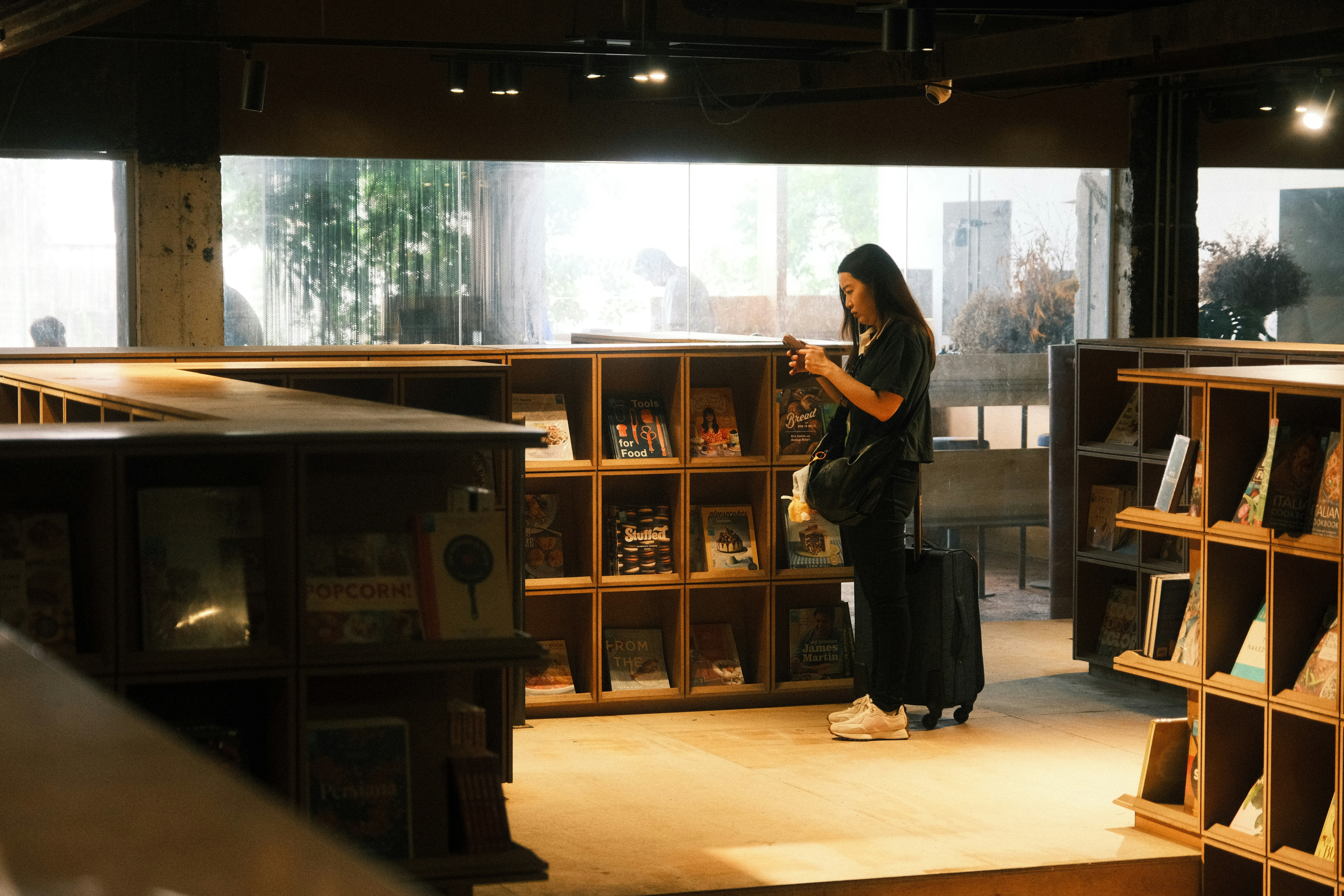 A warm, inviting bookstore at REXKL in Kuala Lumpur, featuring neatly organized bookshelves and soft lighting. The space is designed for book lovers to relax and immerse themselves in literature.