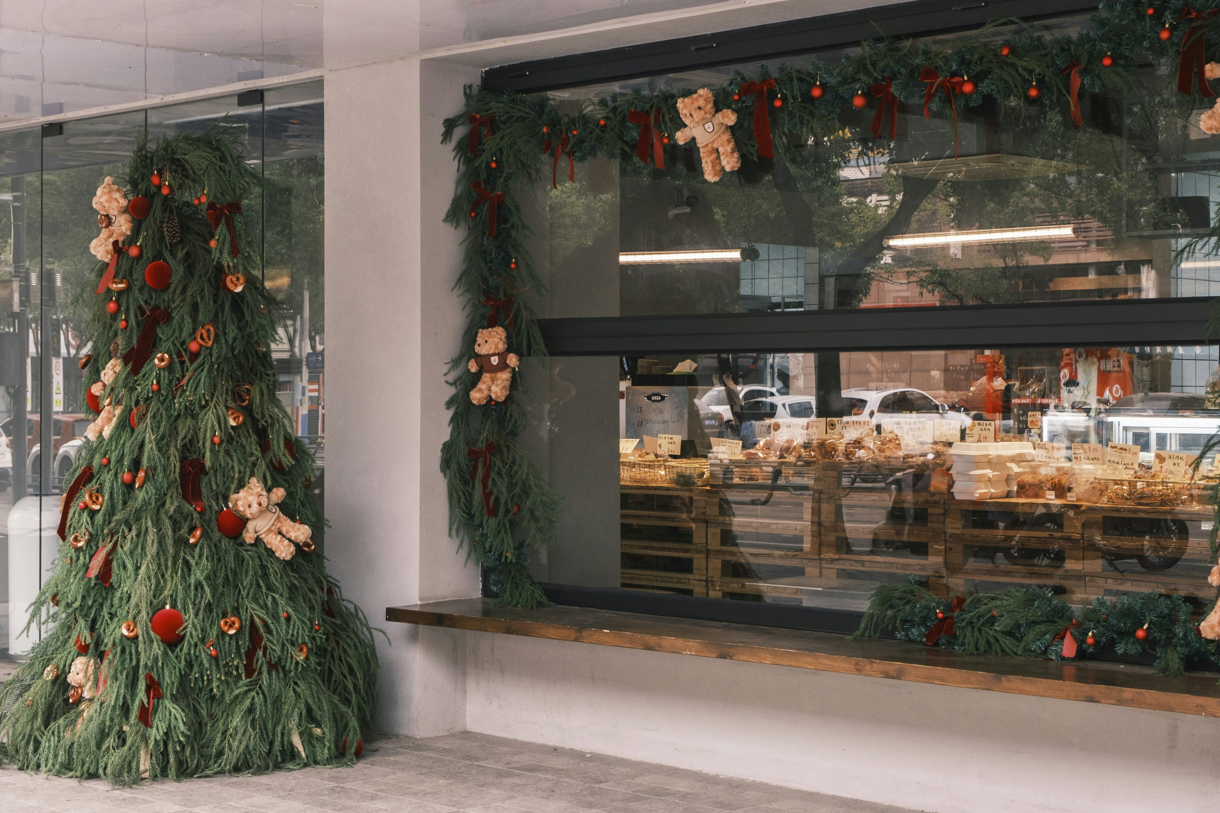 Holiday storefront with evergreen displays and teddy accents