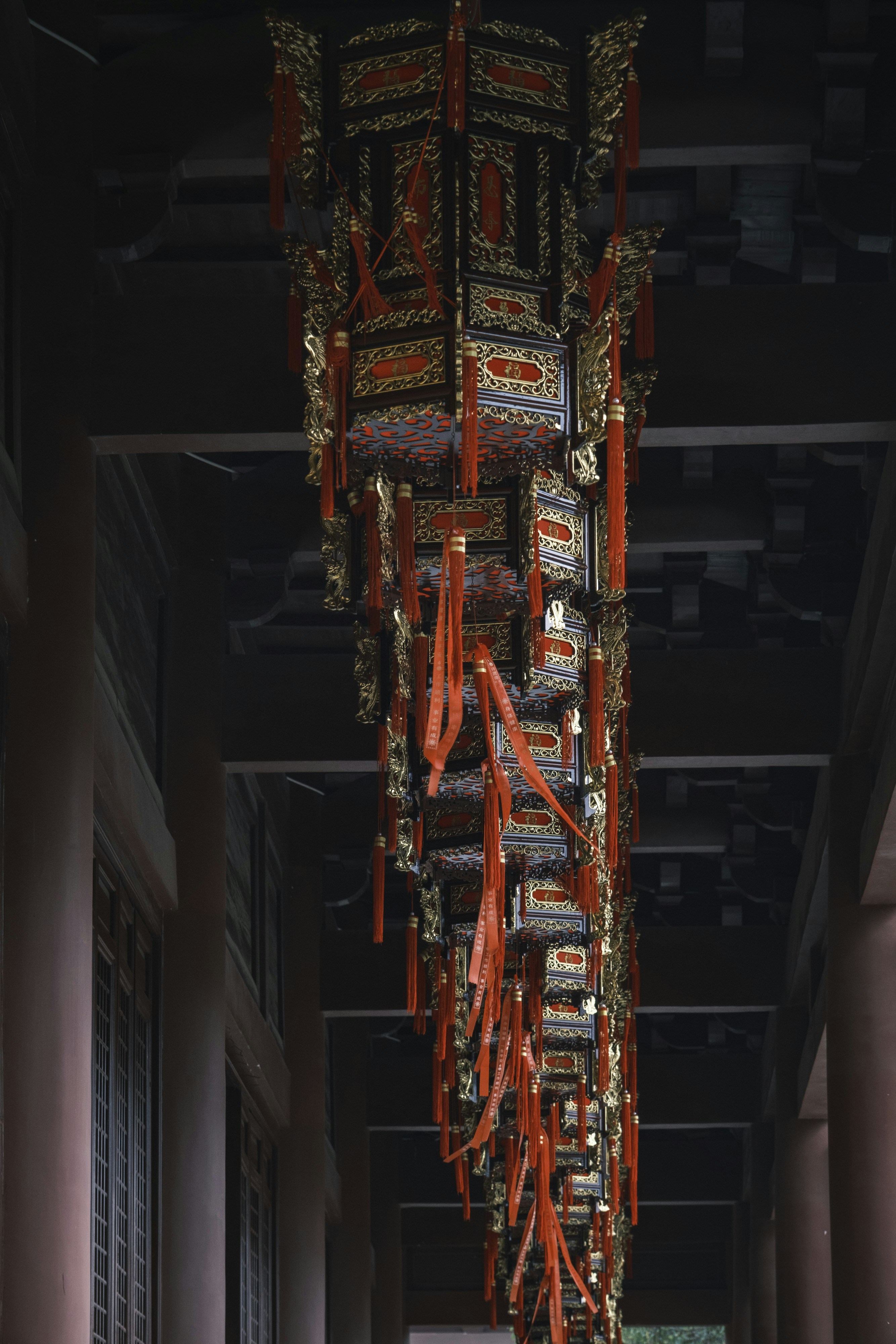 Ornate Red-and-Gold Lanterns Suspended in a Dim Palace Corridor