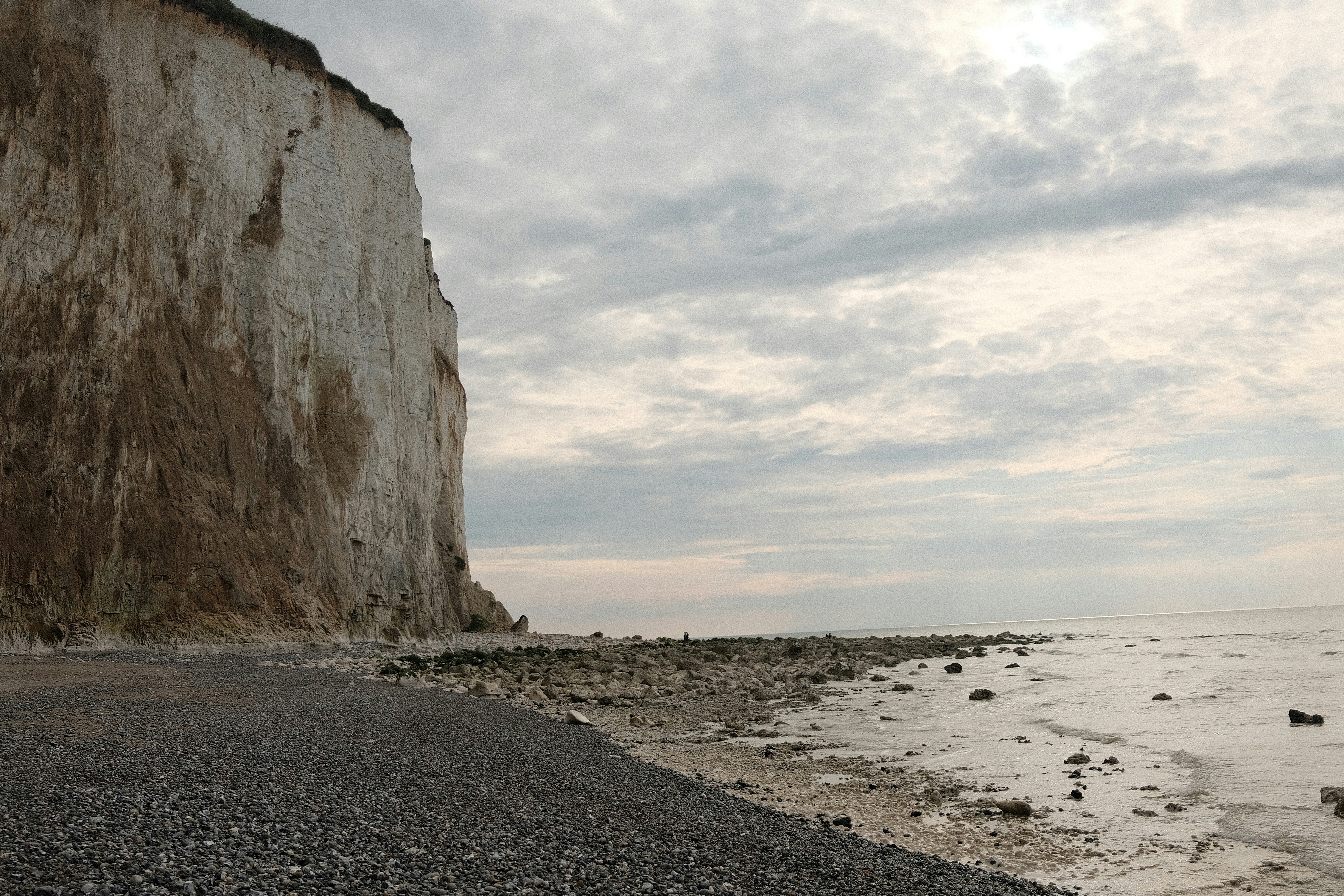 Acantilados blancos con vistas a una playa rocosa y un mar en calma ...