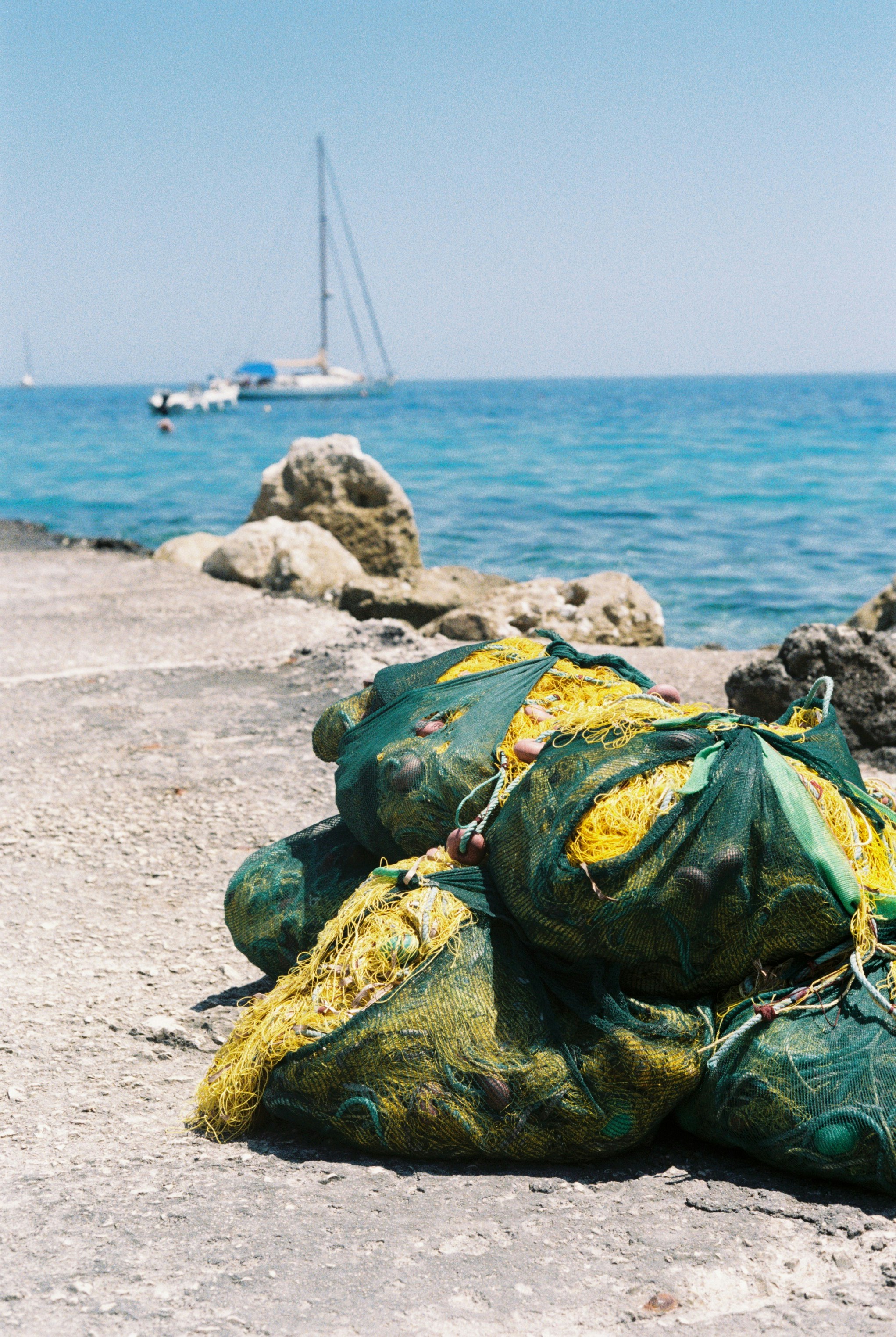 Tangled nets by the harbor: sunlight and sea resolve the shore
