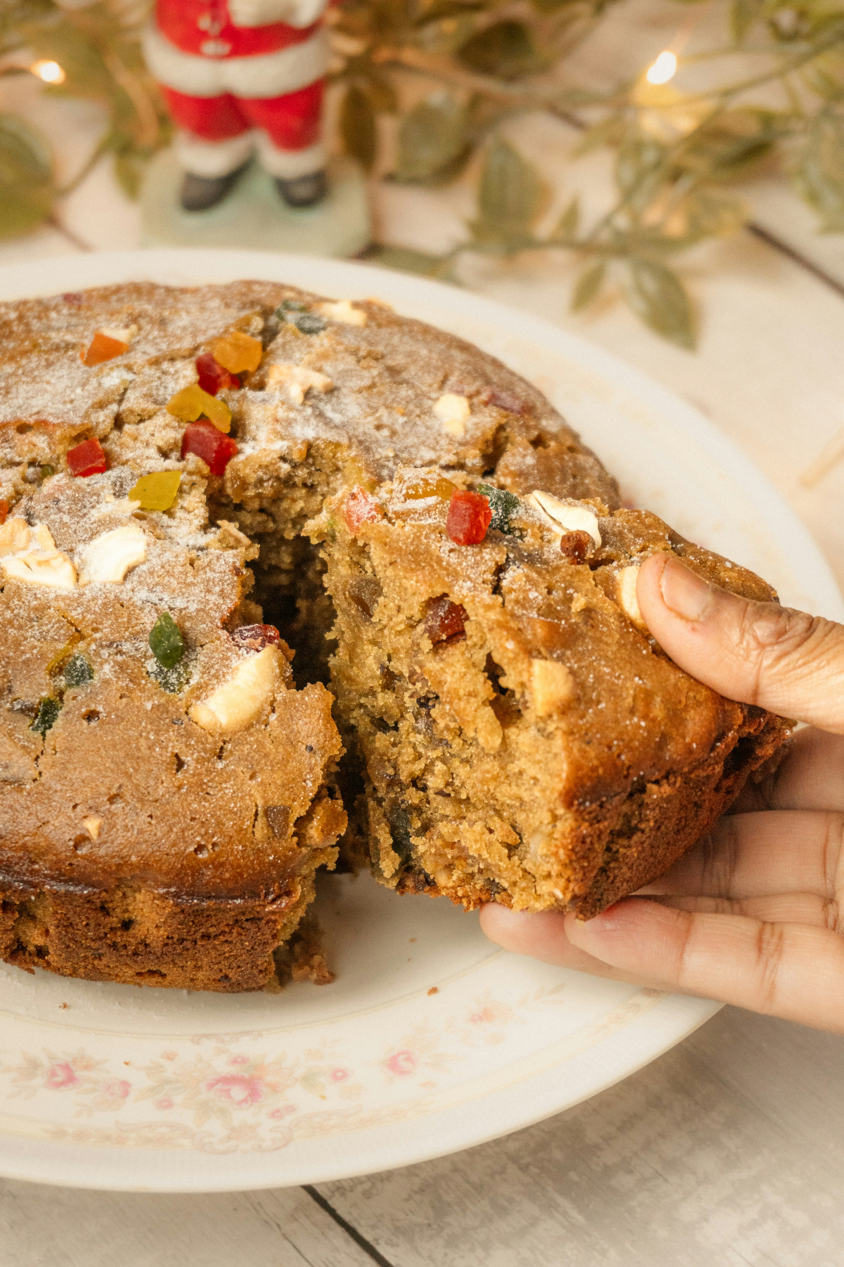 Chunky fruitcake finale: hands pull apart a sugared, nut-studded slice