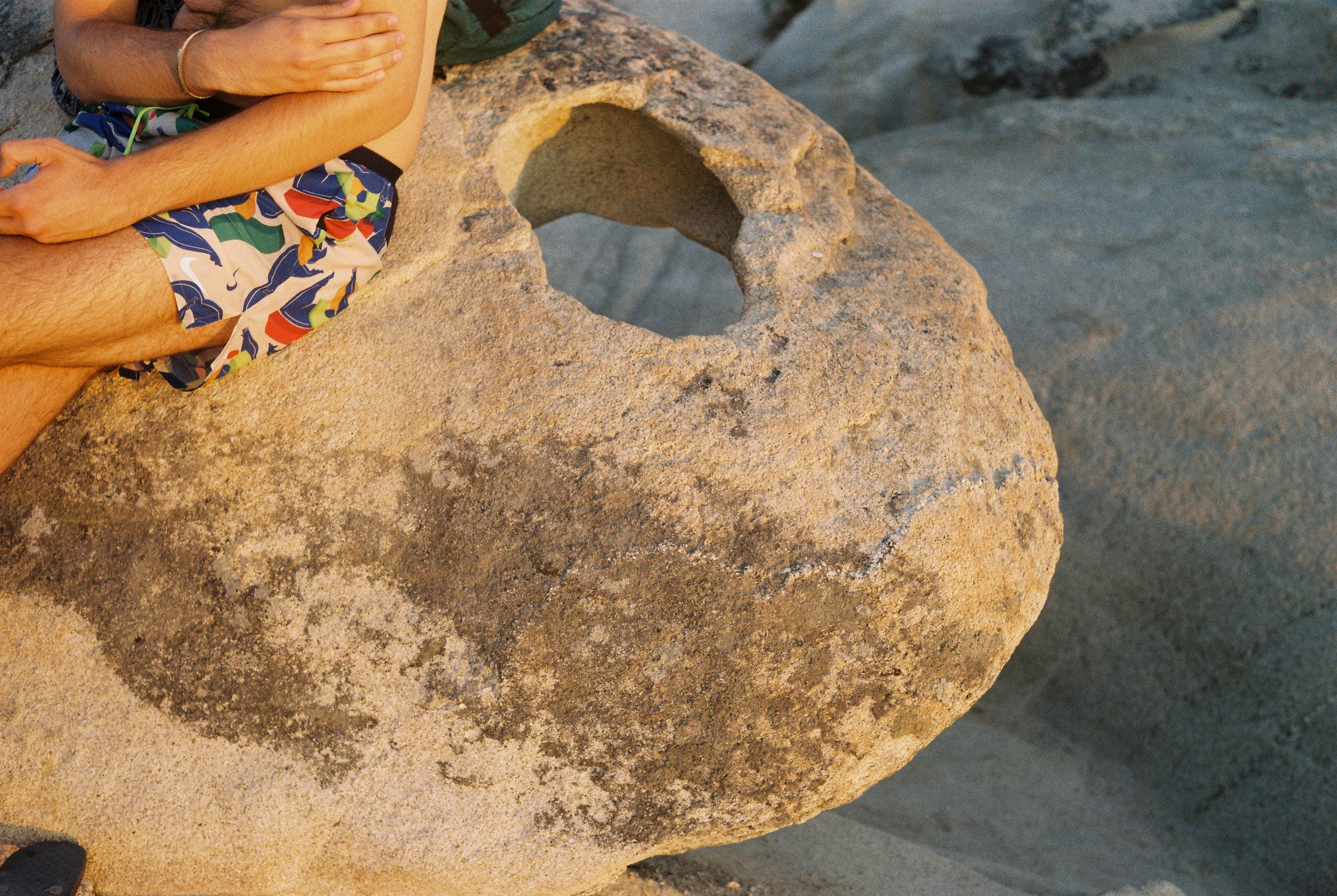 Sunlit Kerb: A Child's Hand resting on a Weathered Stone Ring