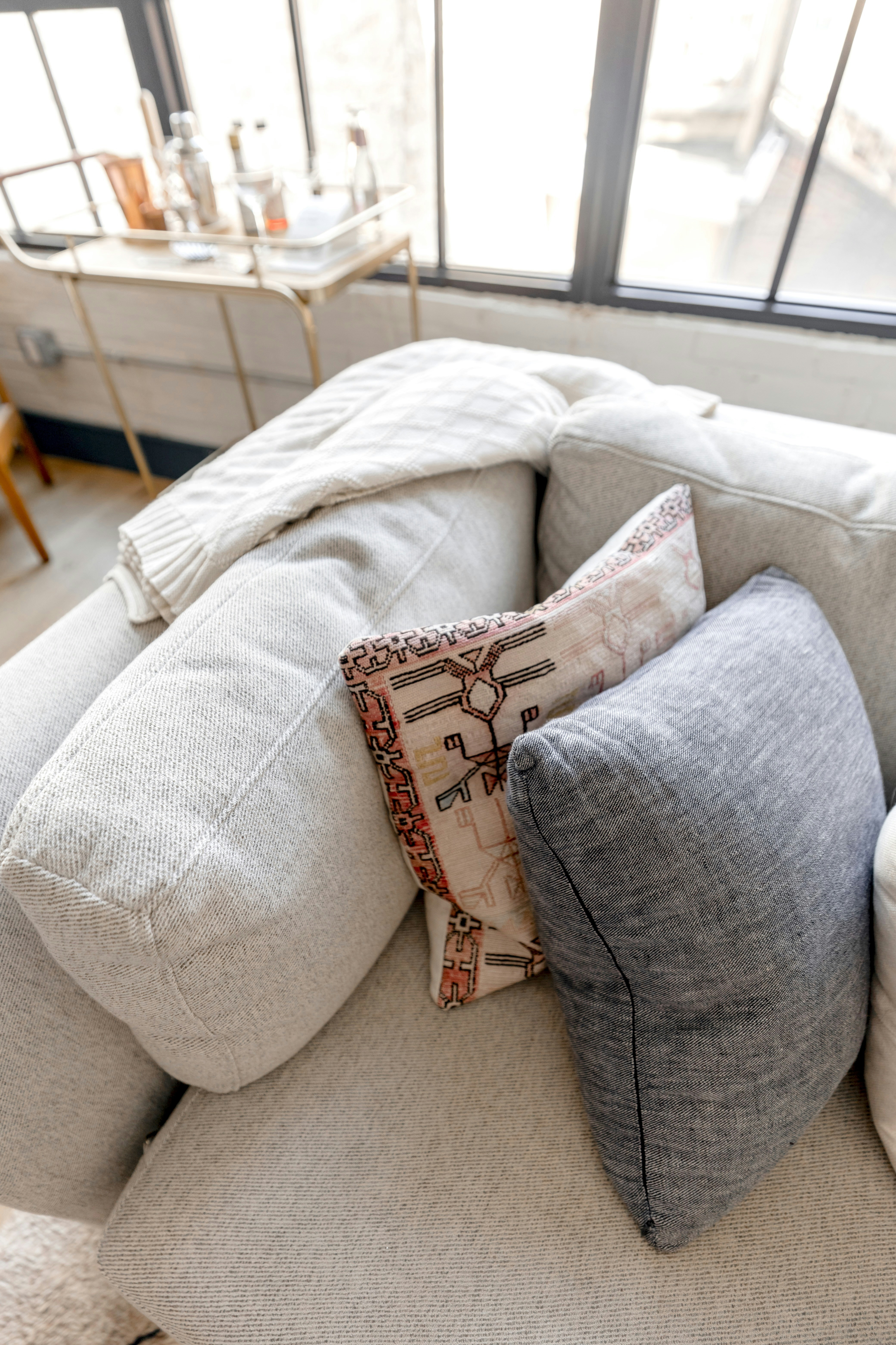 Cozy Throw: Cushions and Light in a Sunlit Lounge