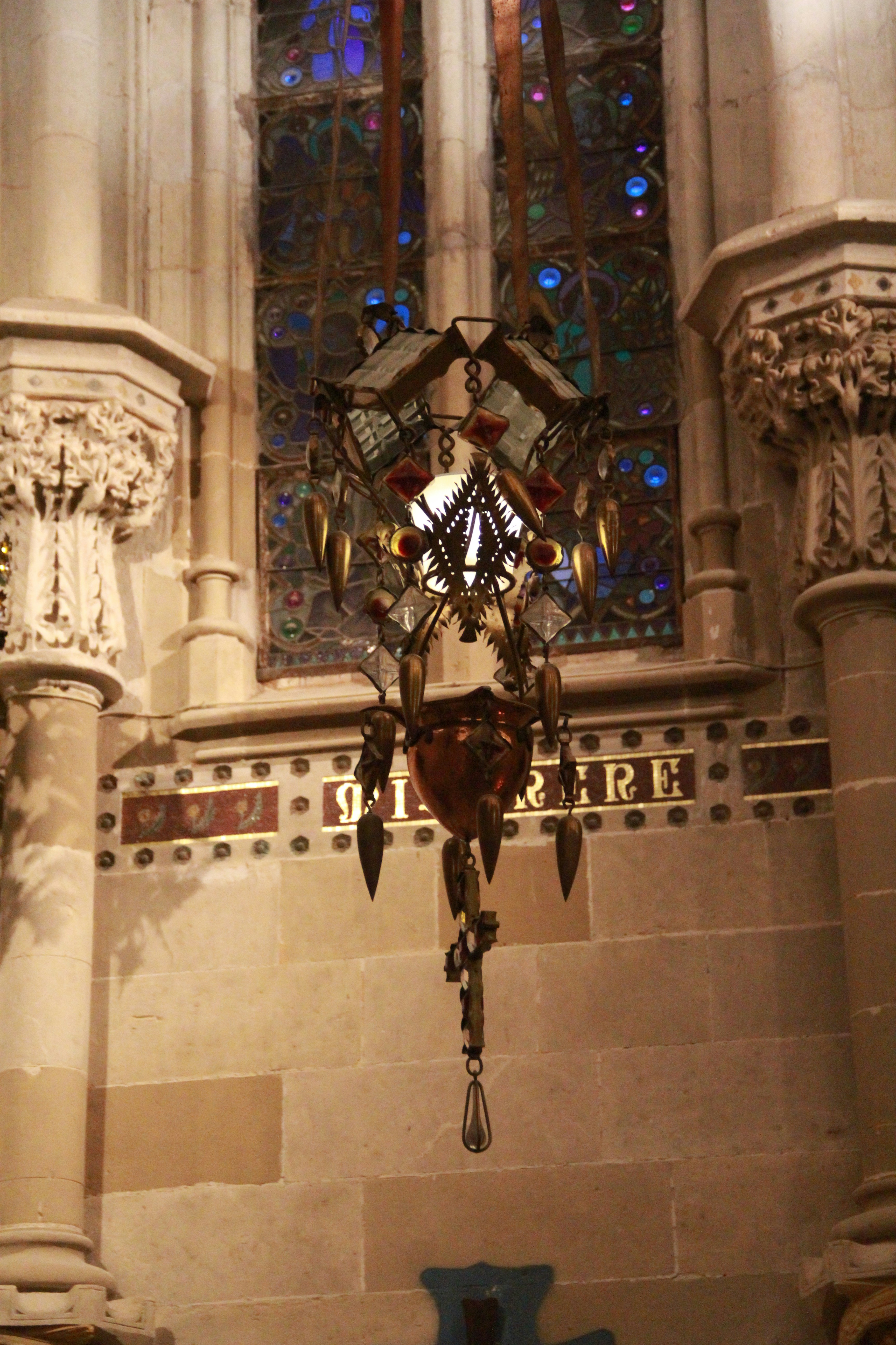 Stained glass glow and hanging ornament in a sacred interior
