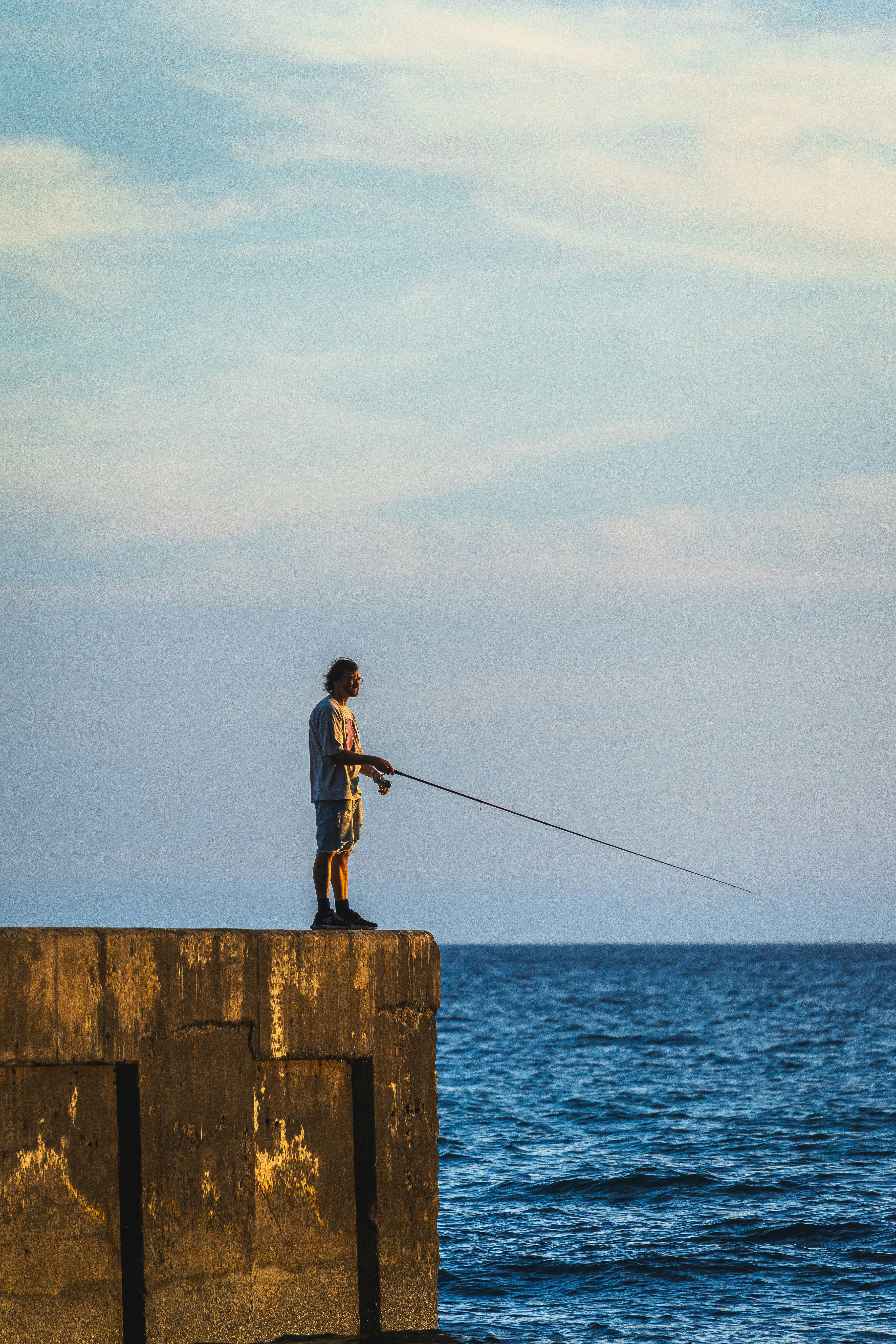 Lonely Angler at the Edge of Sea