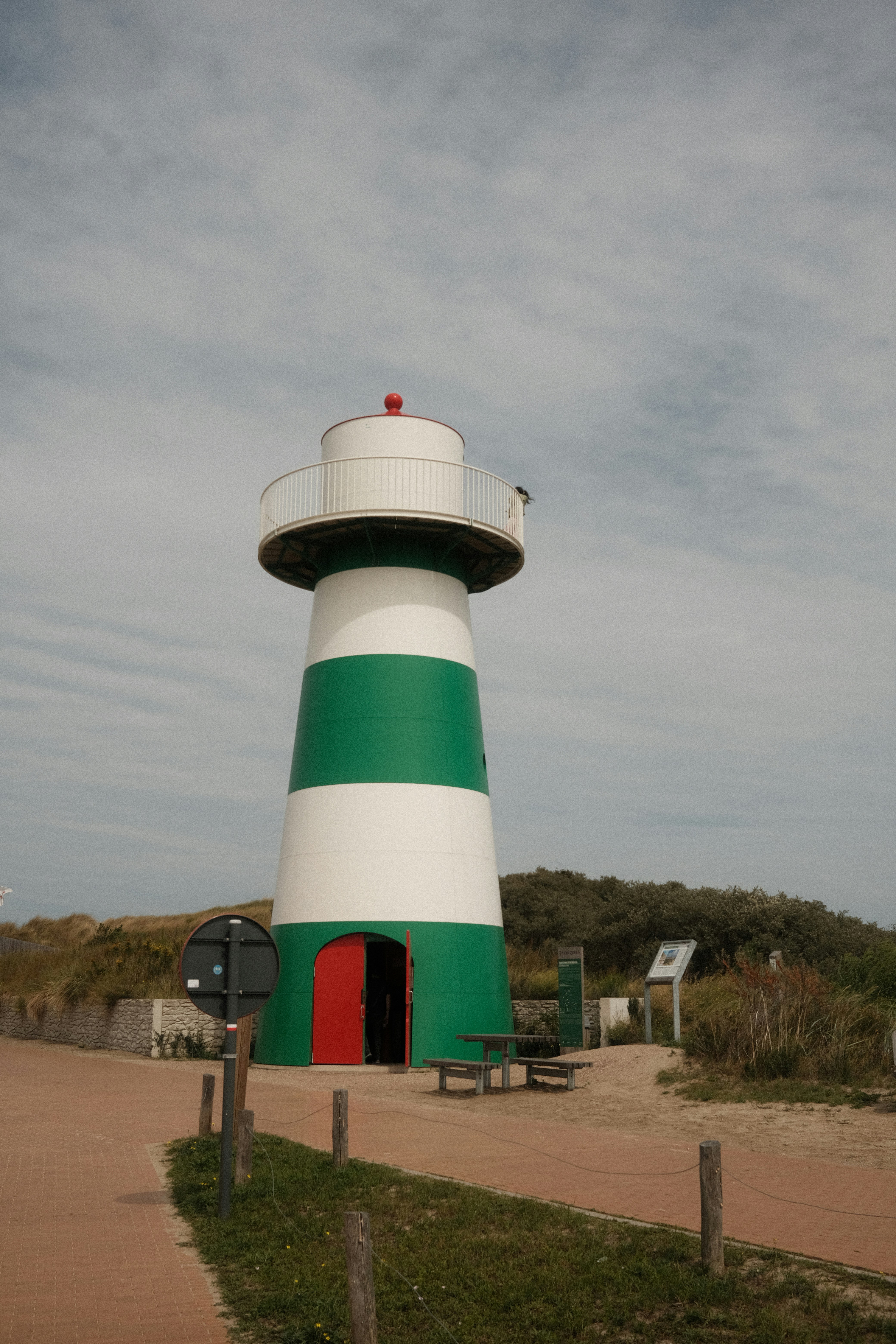 Green-and-White Beacon Against a Quiet Coastal Sky