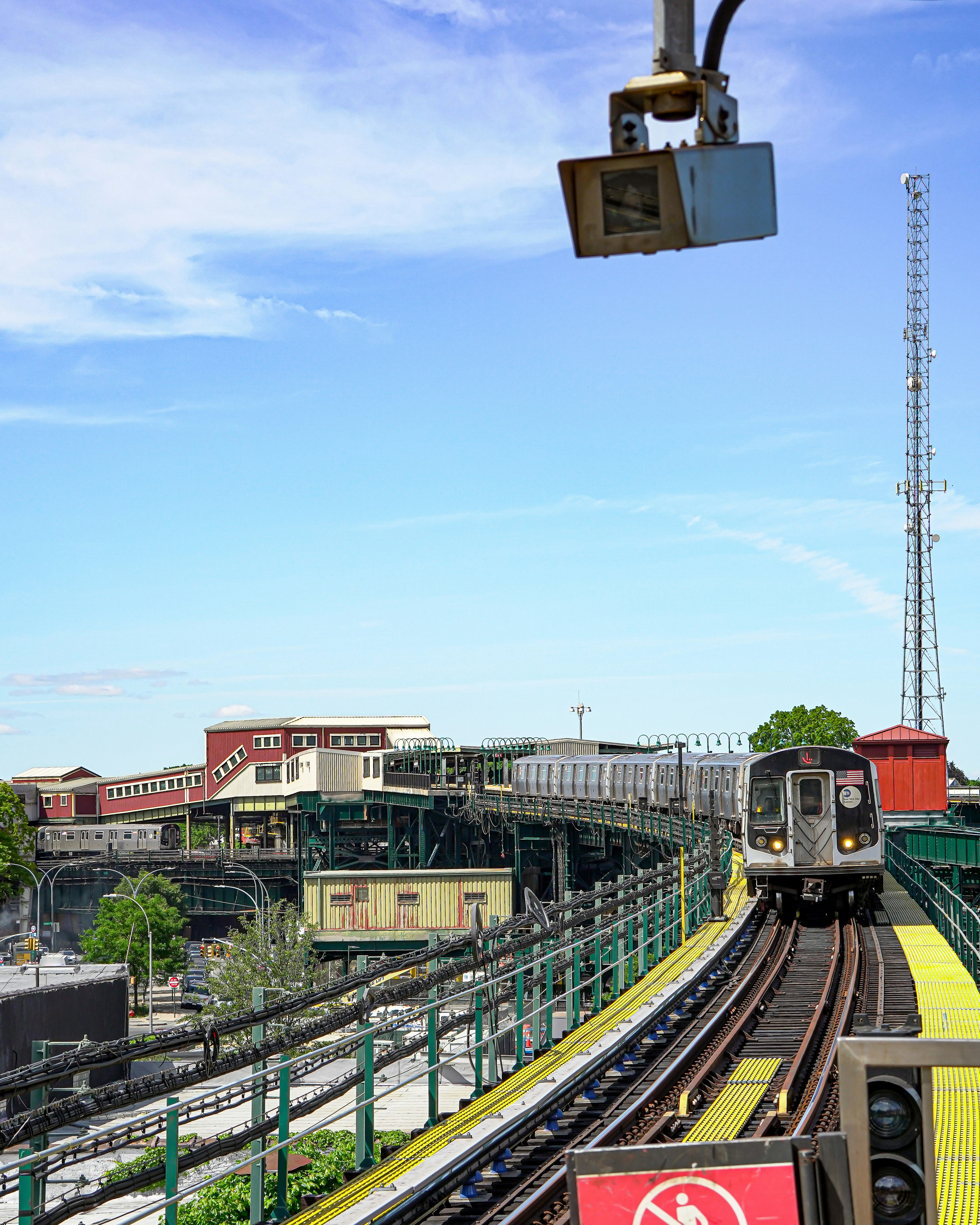 Bridge-and-train at the elevated station bathed in midday light