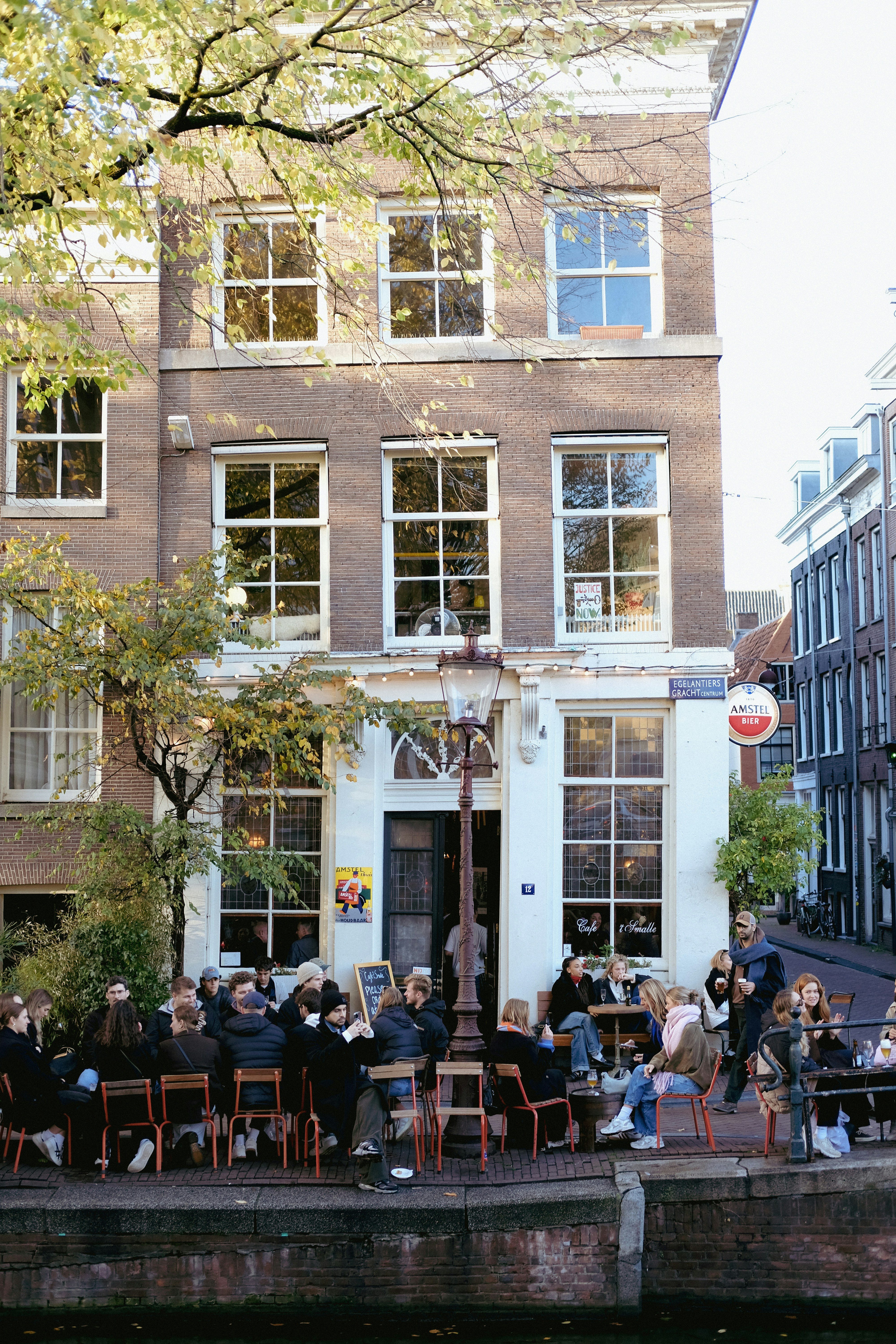 Café by the Canal: People Conversing Under a Brick Building