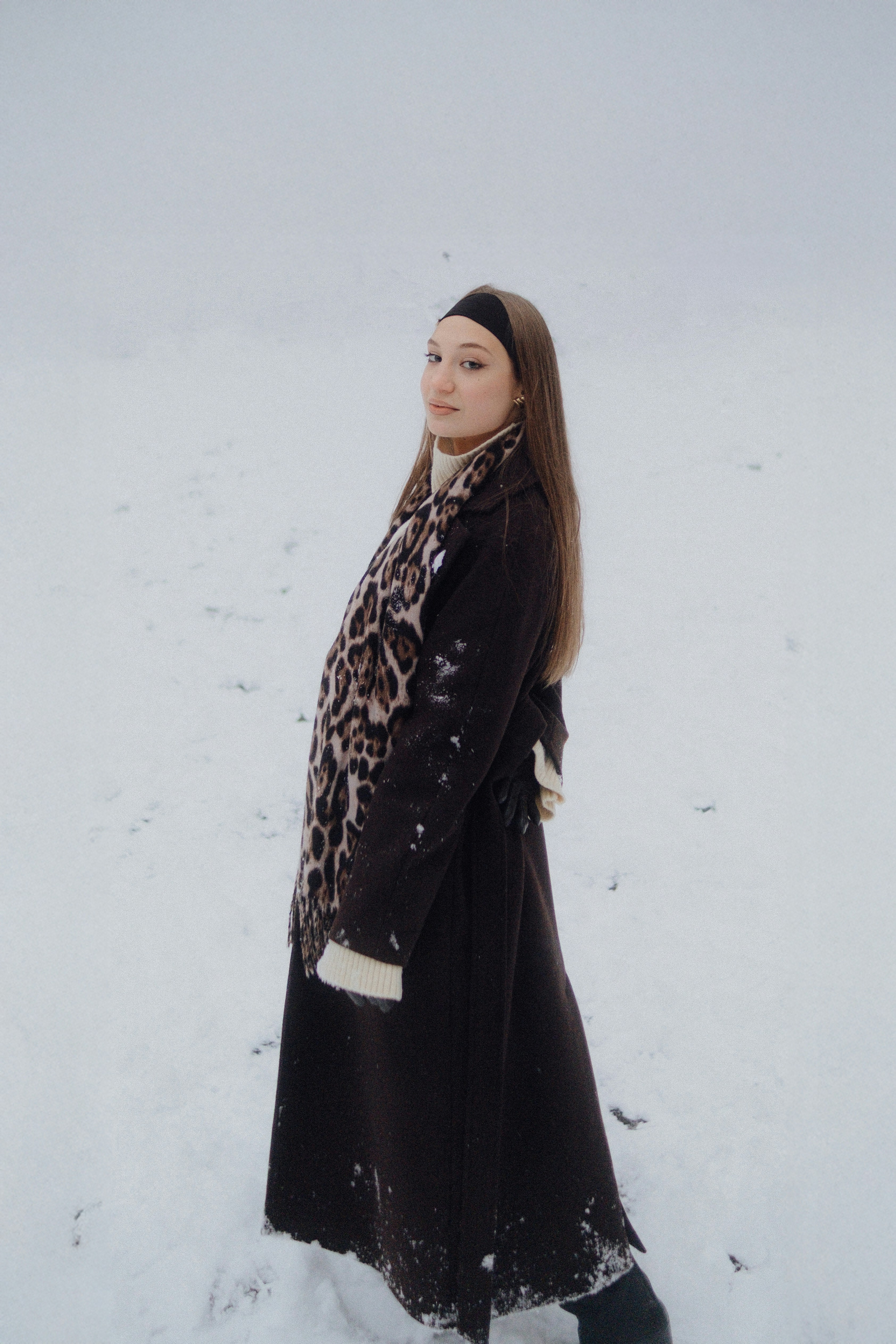 Winter Portrait in Soft Snow: Leopard Scarf and Quiet Dignity