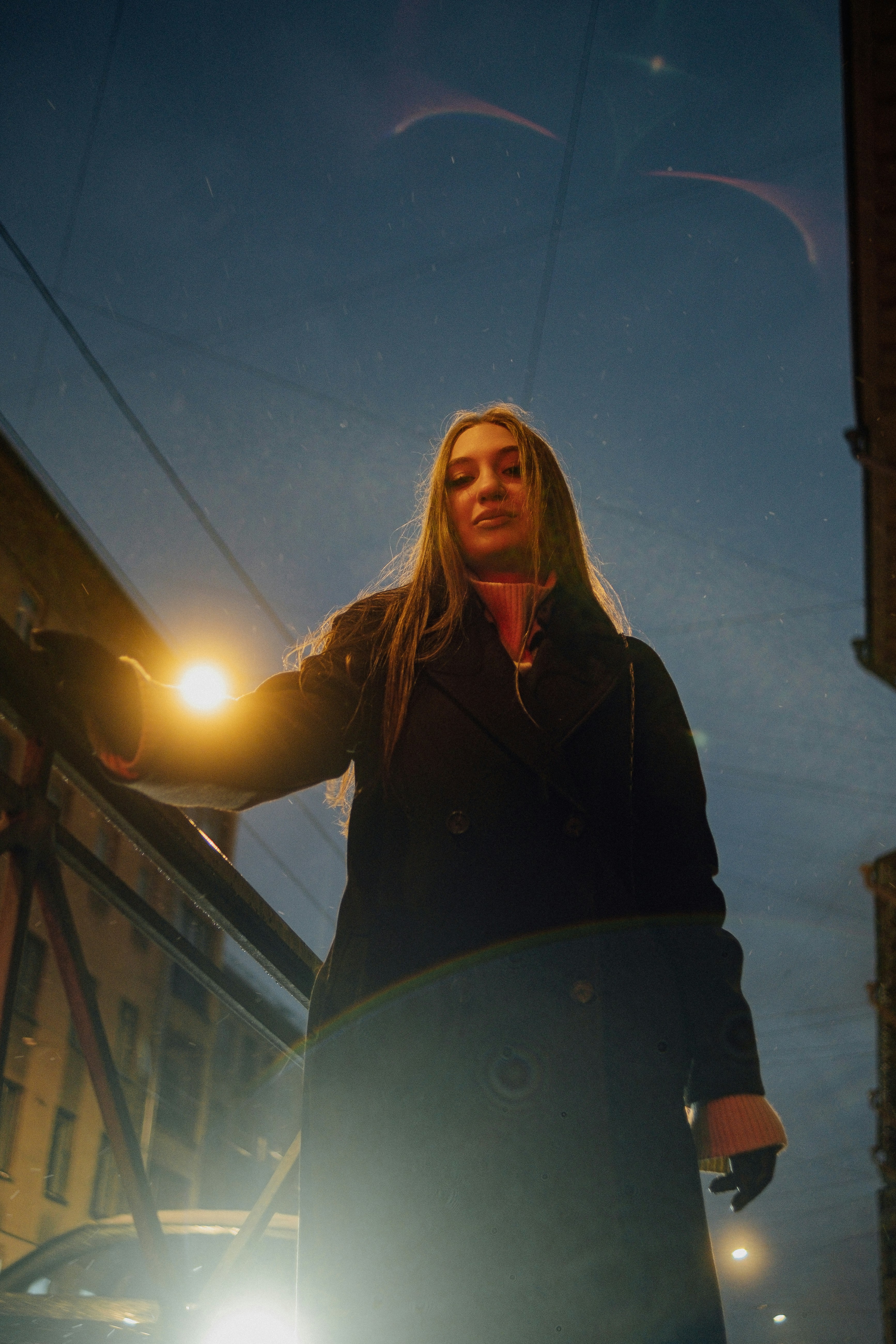 Woman standing under streetlights at night