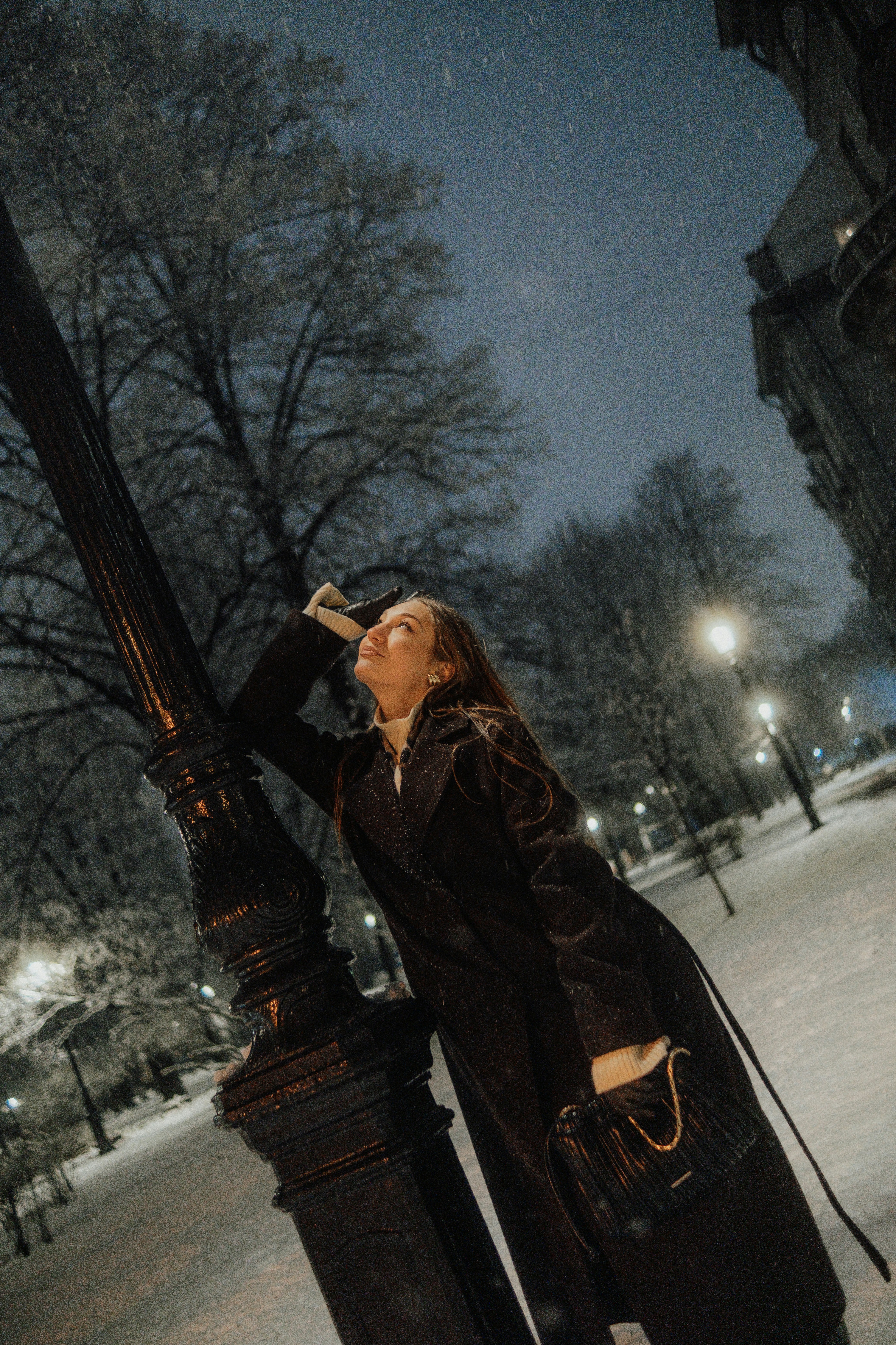 Night Portrait Against a Velvet Snow: Woman Embracing a Streetlamp