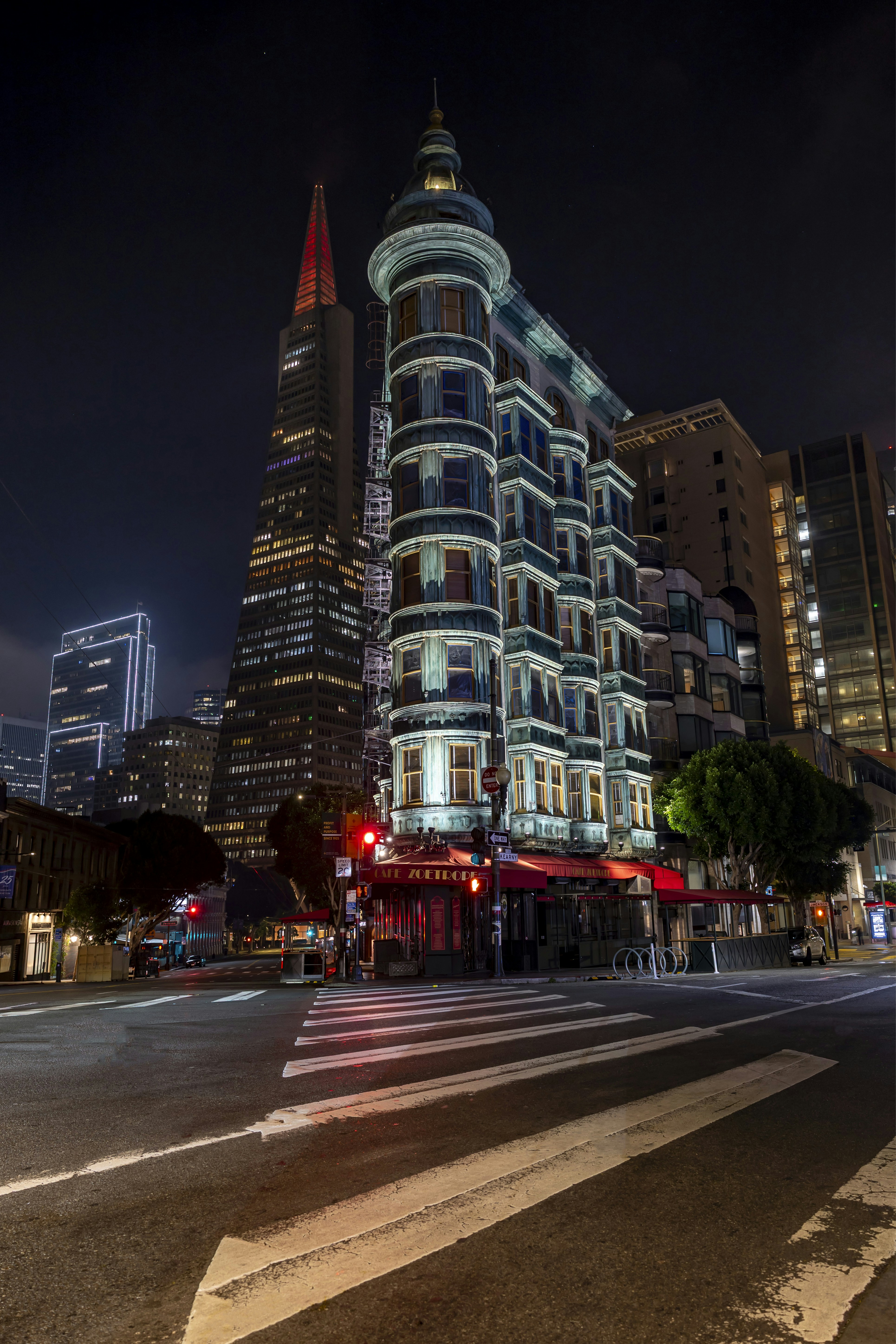 Distinctive historic building at night with modern skyscrapers.