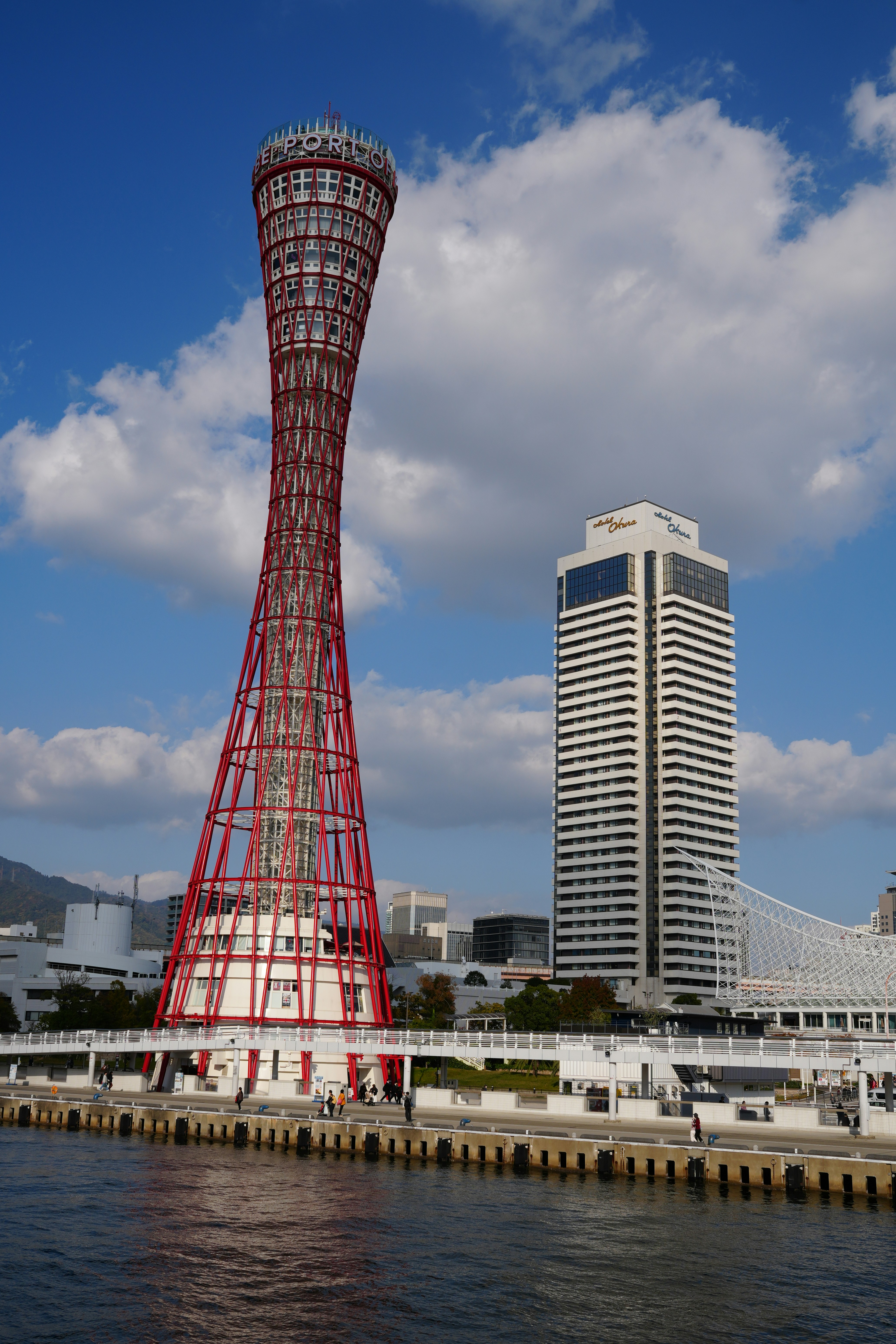 Red Tower by the Waterfront: A City Landmark Against a Bright Sky