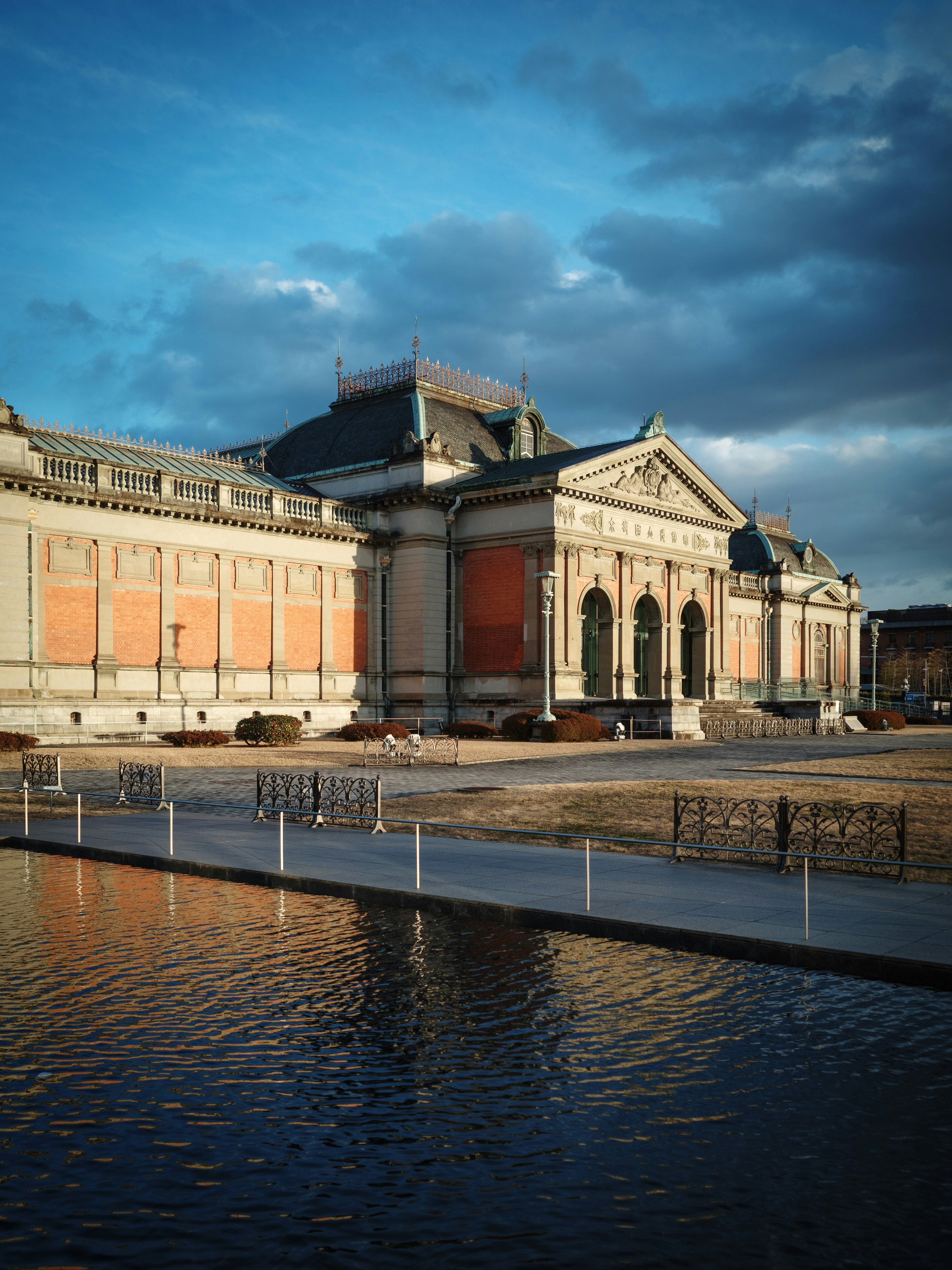 Sunlit Neoclassical Pavilion Reflected in Quiet Canal