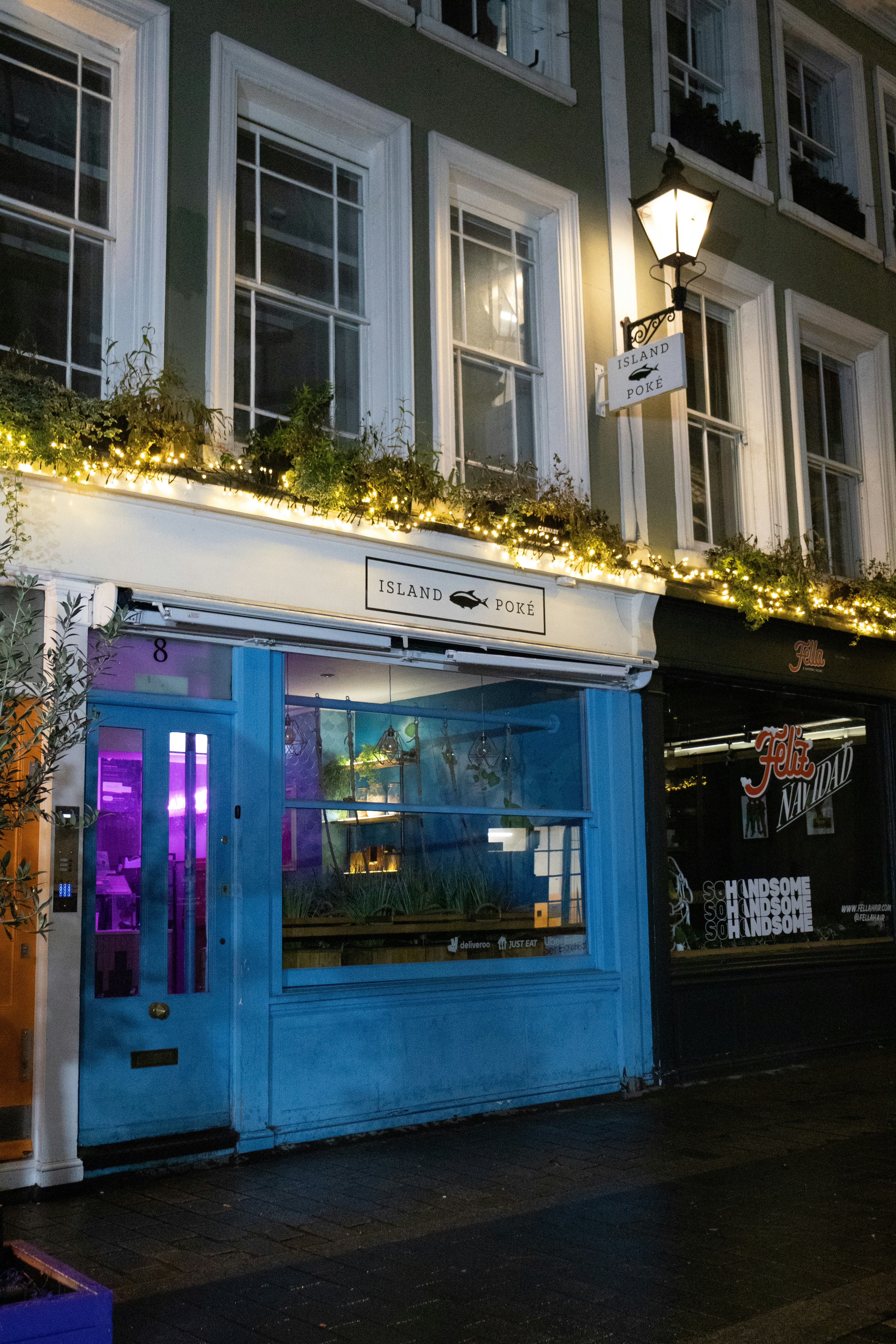 Blue storefront glow under a festive string of lights