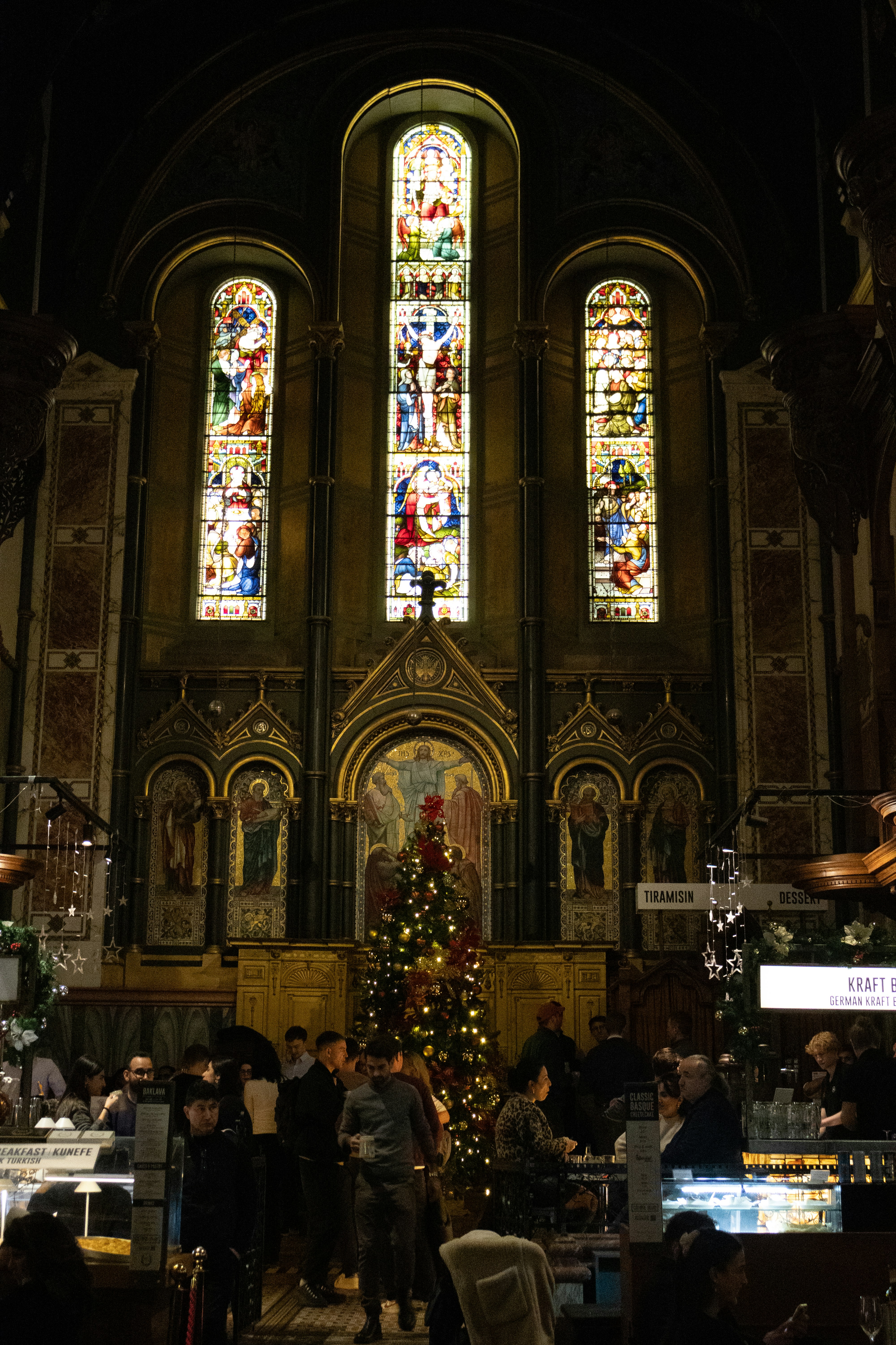 Christmas tree inside a church with stained glass windows