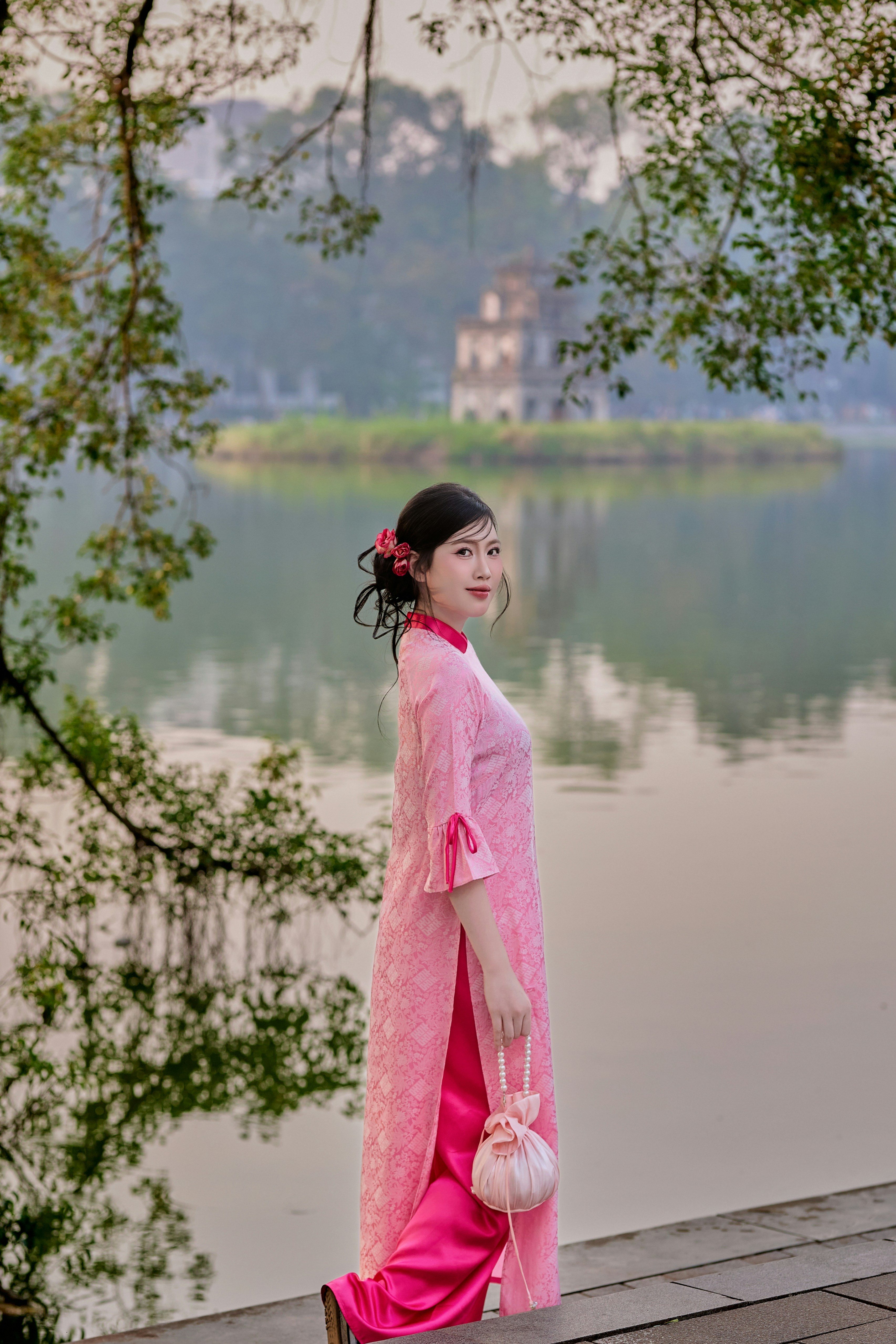 Grace by the Lake: A Woman in Pink Cheongsam Beside Serene Waters
