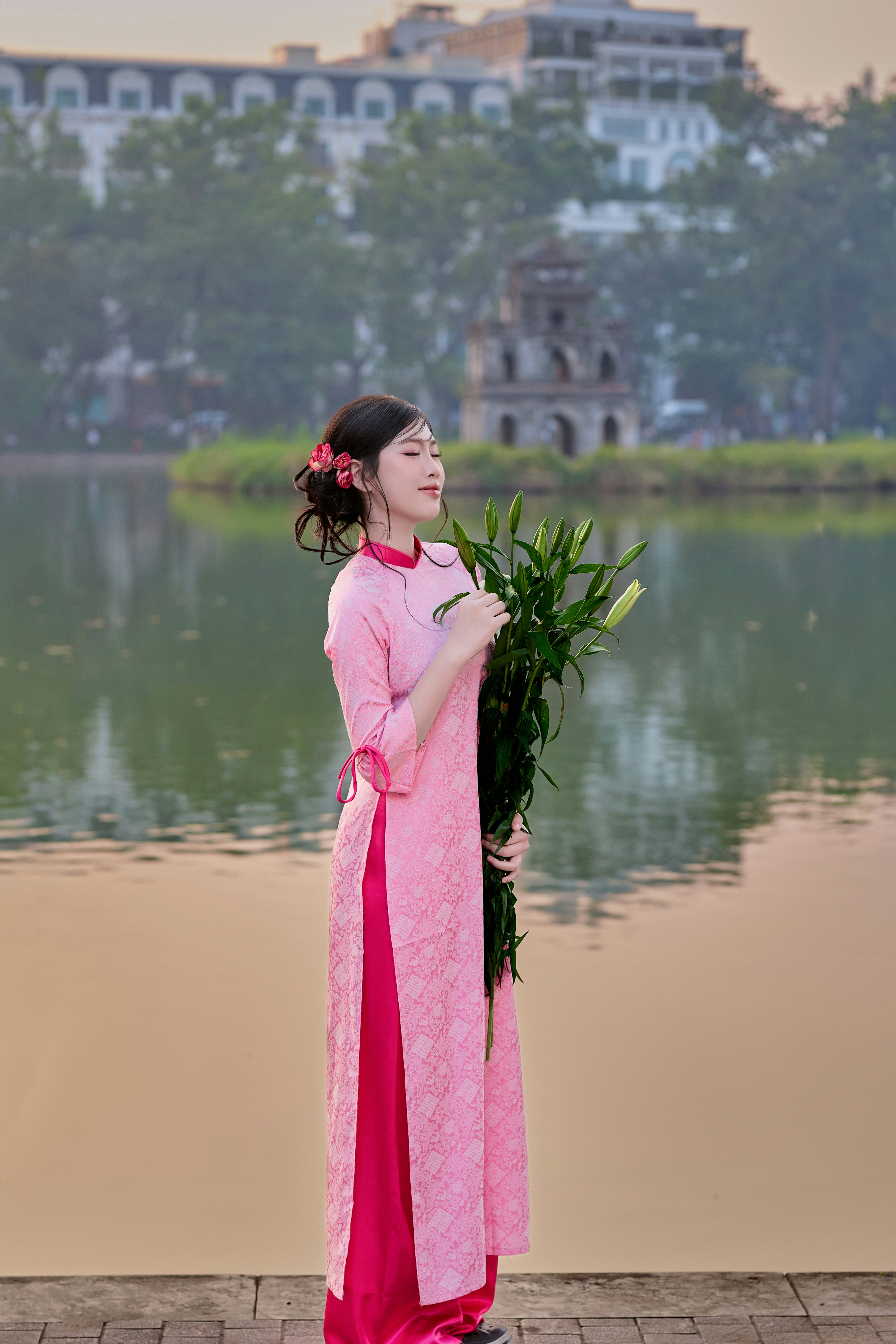Femme en robe rose tenant des lys près d’un lac photo – Image gratuite ...
