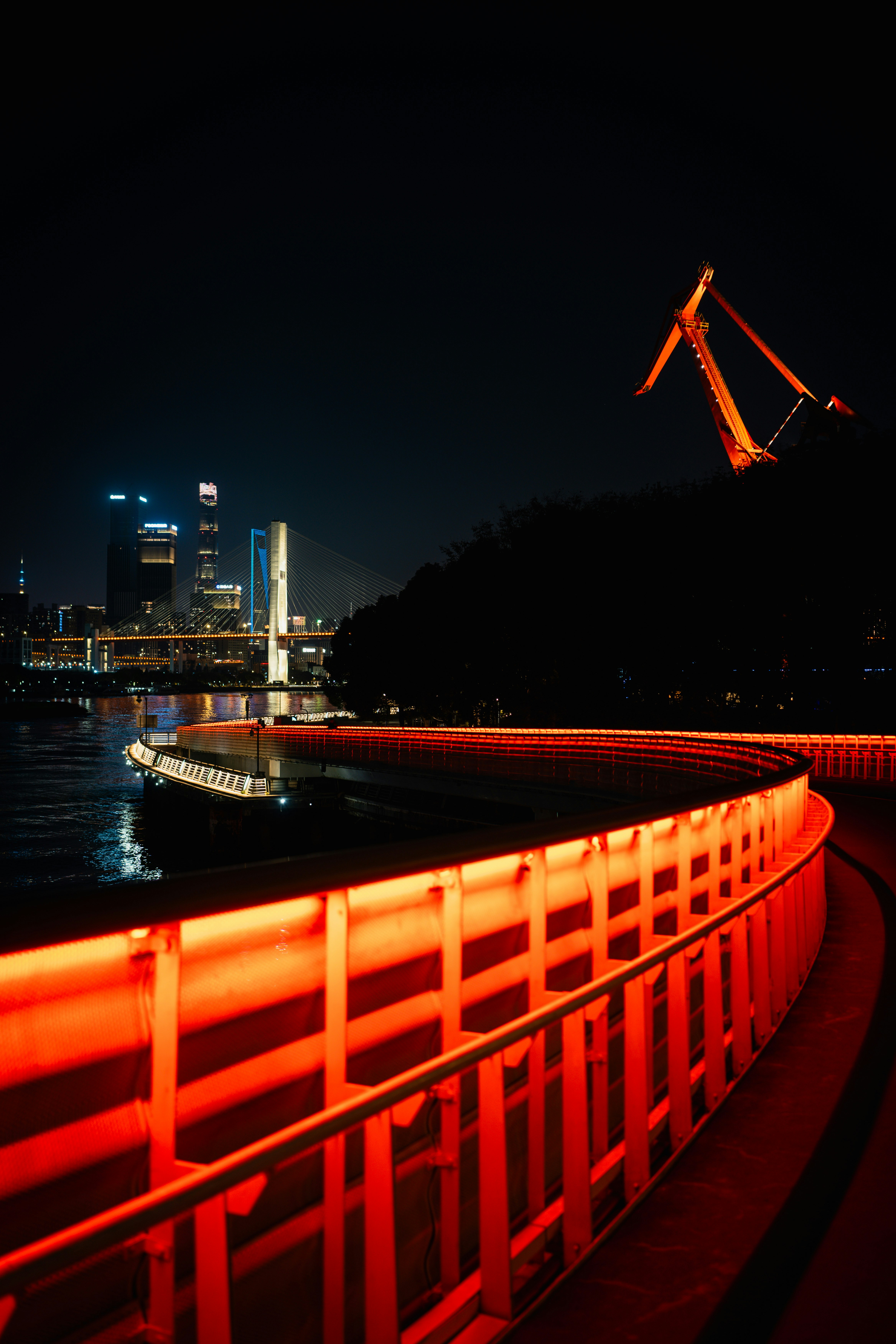 Neon Riverscape: Red Handrail Winding Toward the City