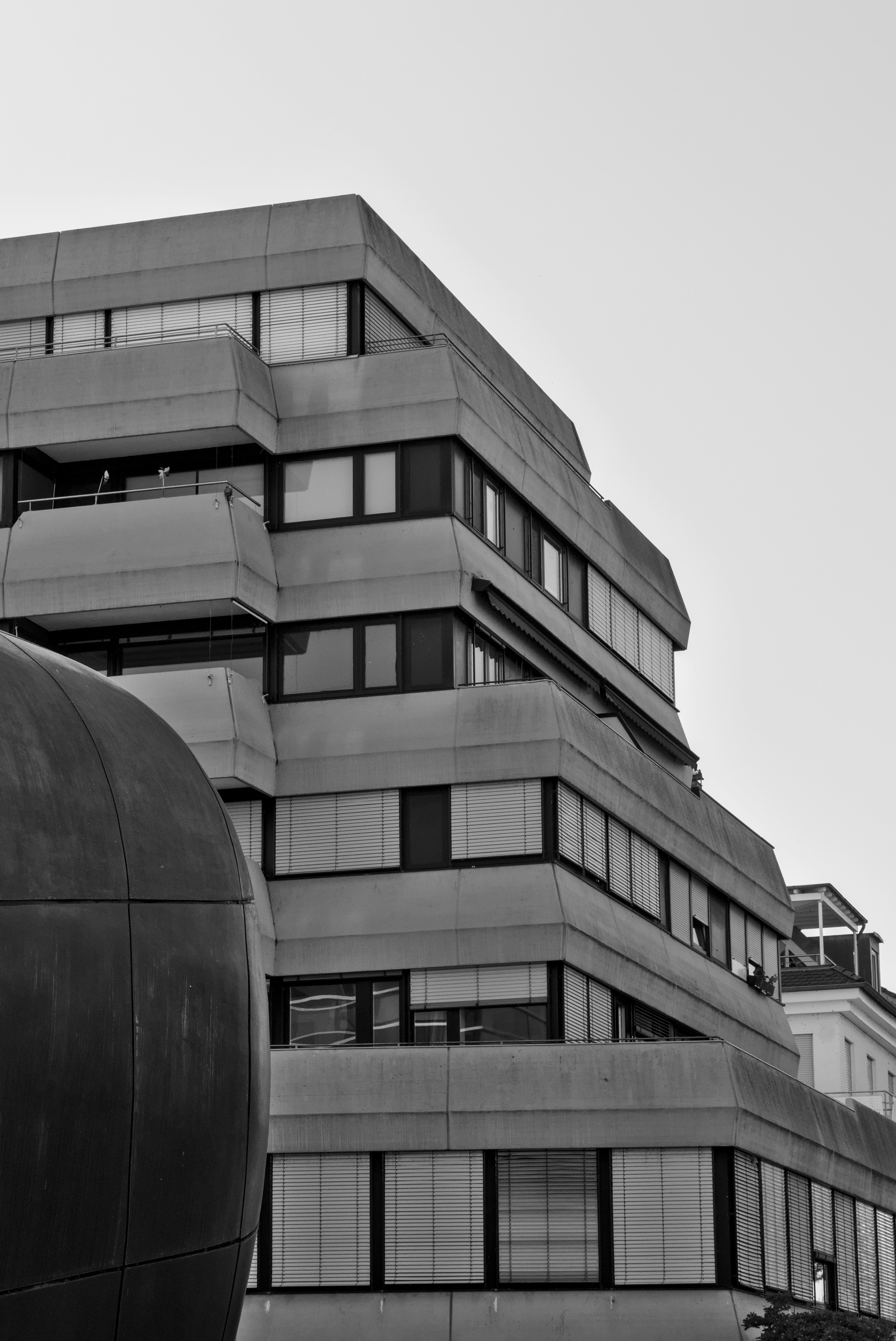 Concrete Geometry: A Towering Layered Facade Against a Pale Sky