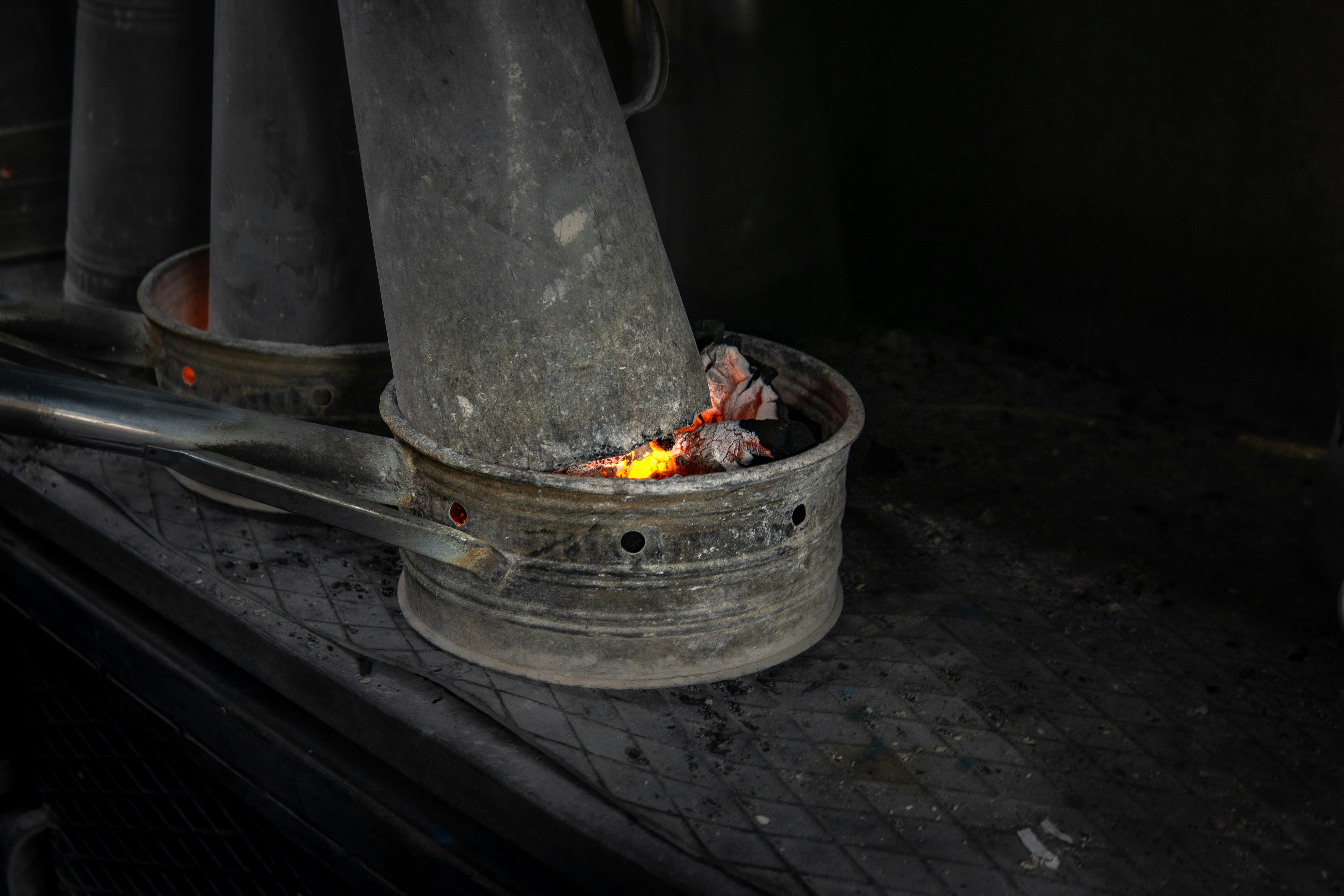 Cauterized Flame in a Metal Recess: A Close-Up of Fire and Ash