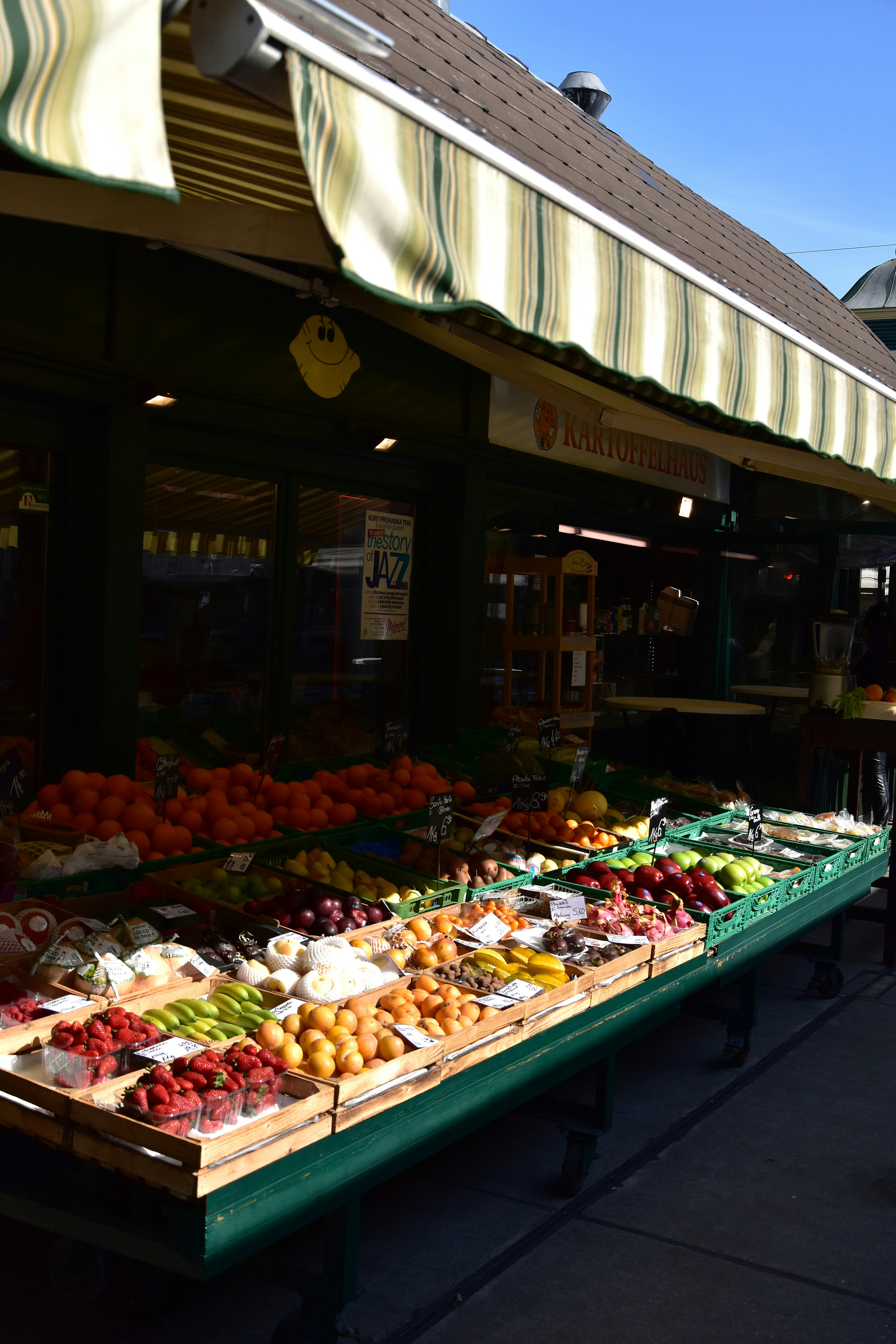 Bustling Fruit Stand Under Green Awning at a Market