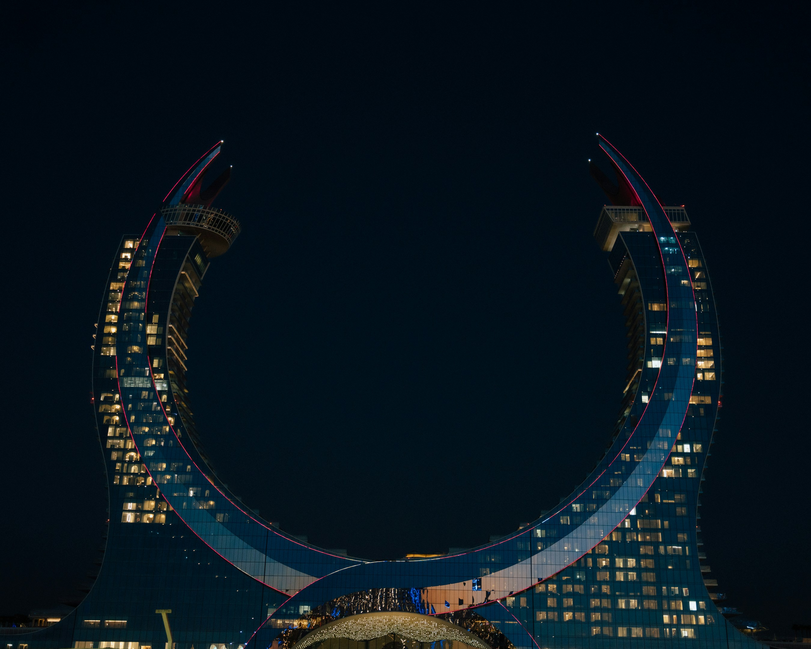 Modern crescent-shaped building illuminated at night photo – Free ...