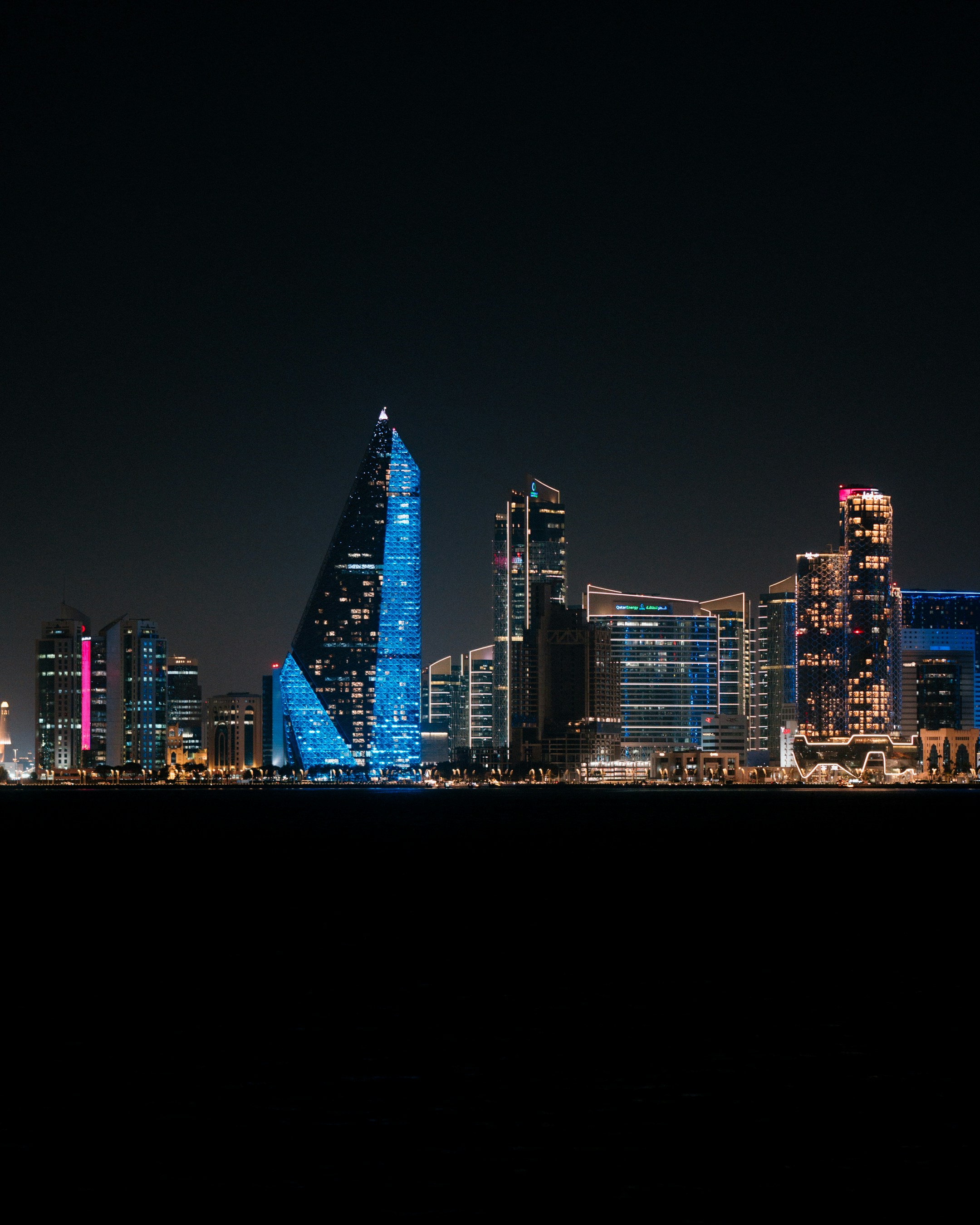 Un paysage urbain moderne illuminé la nuit par des gratte-ciel lumineux ...