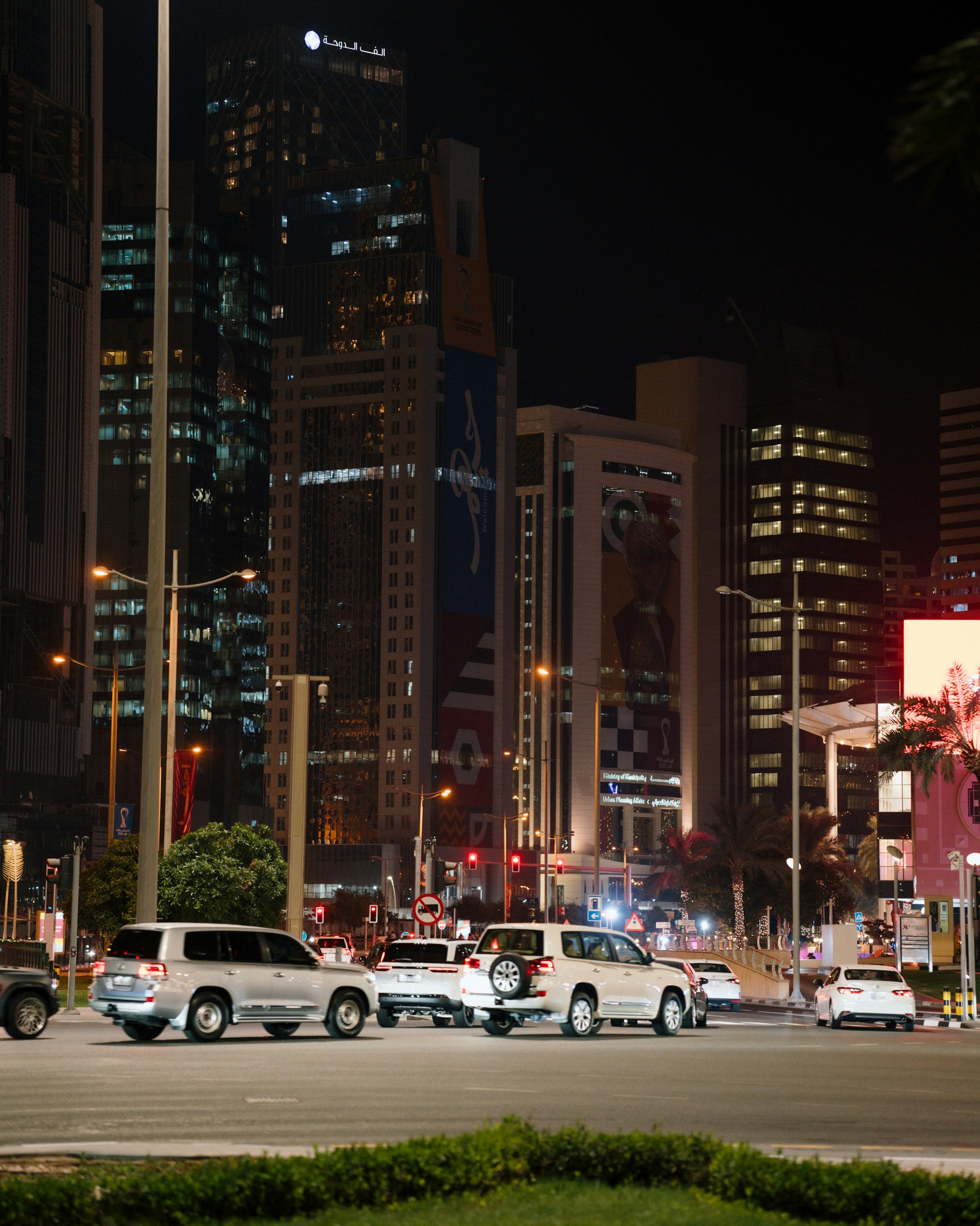 Neon Boulevard: Night Traffic Beneath Skyscraper Belly