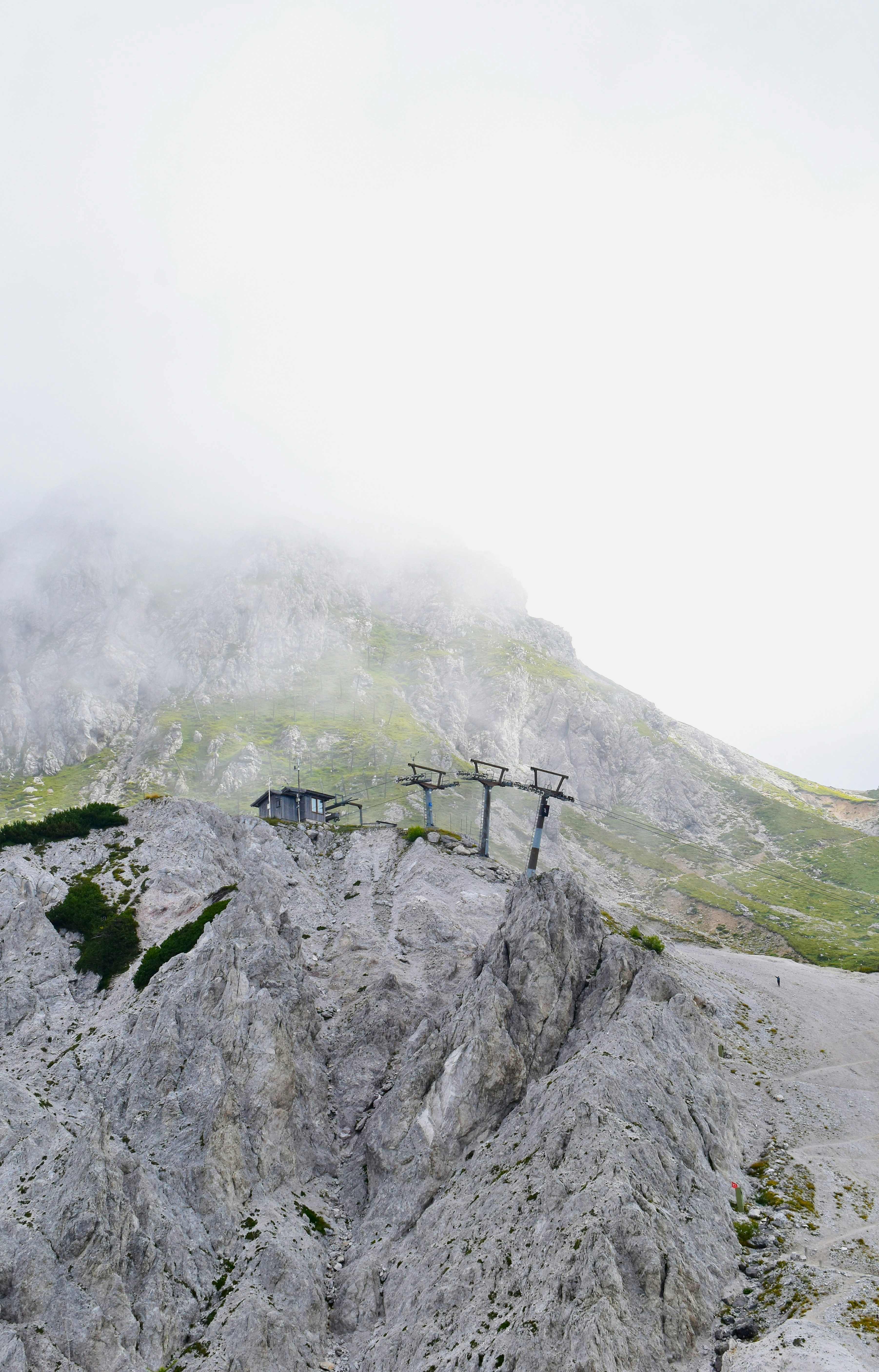Mist-veiled ridgeline and a lone ski-lift silhouette