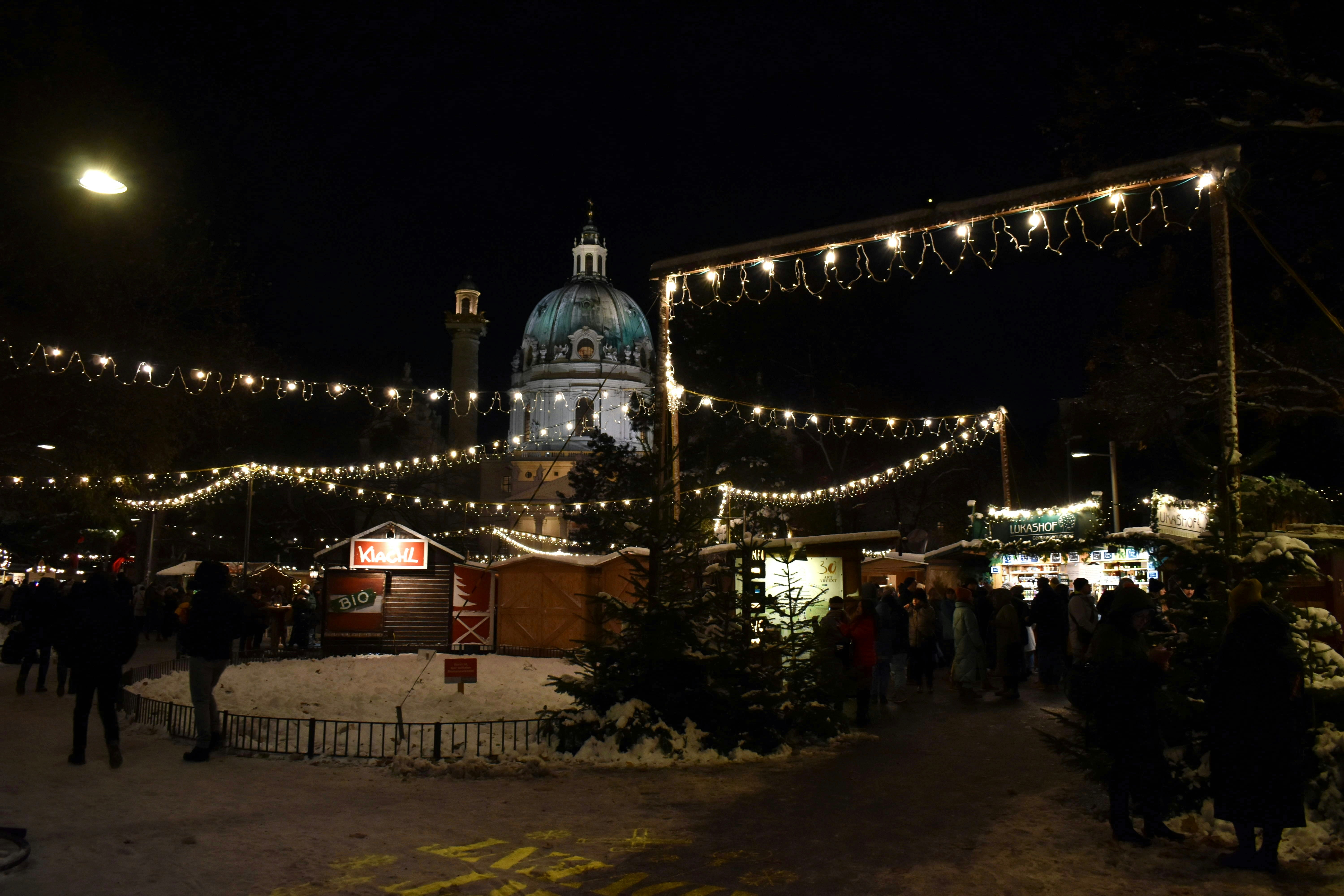 Night Market under Festive Lights by a Dome Cathedral