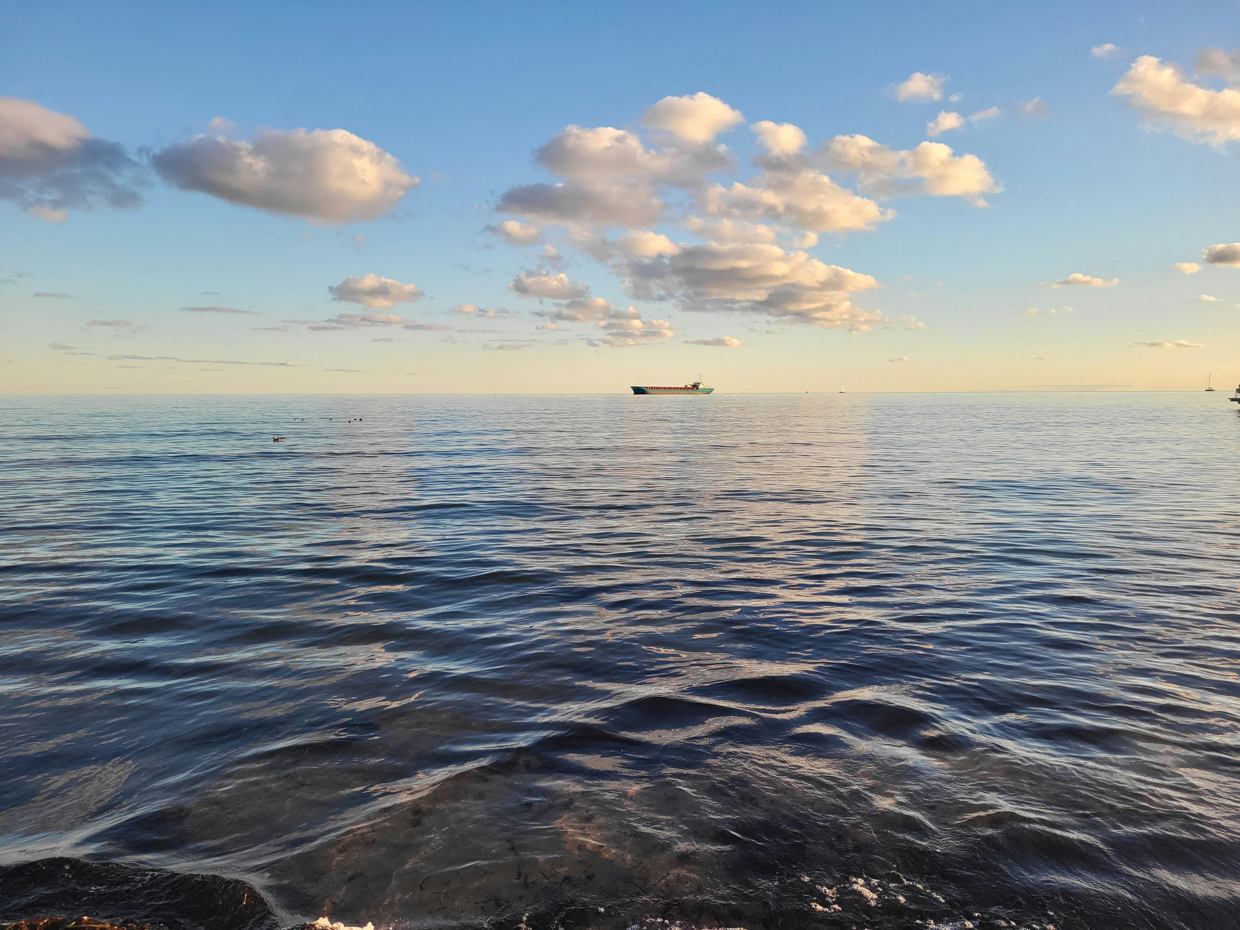 Boat on a calm sea under a pastel sky