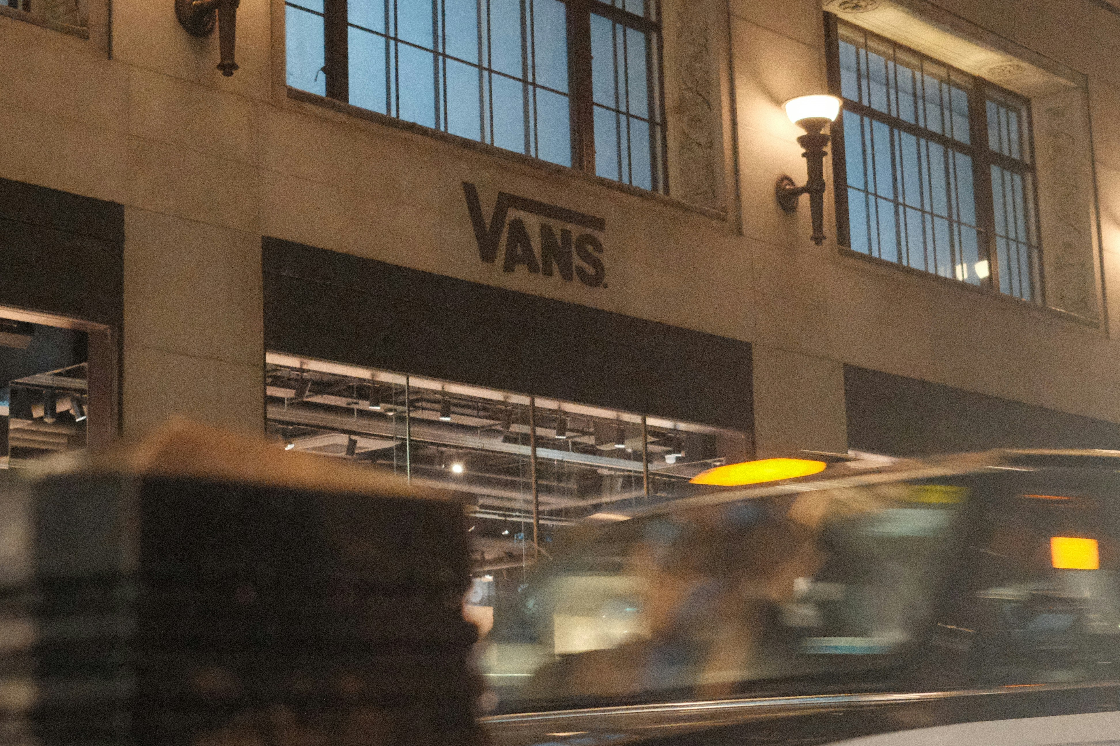 Vans store facade with passing traffic at night photo – Free Fashion ...