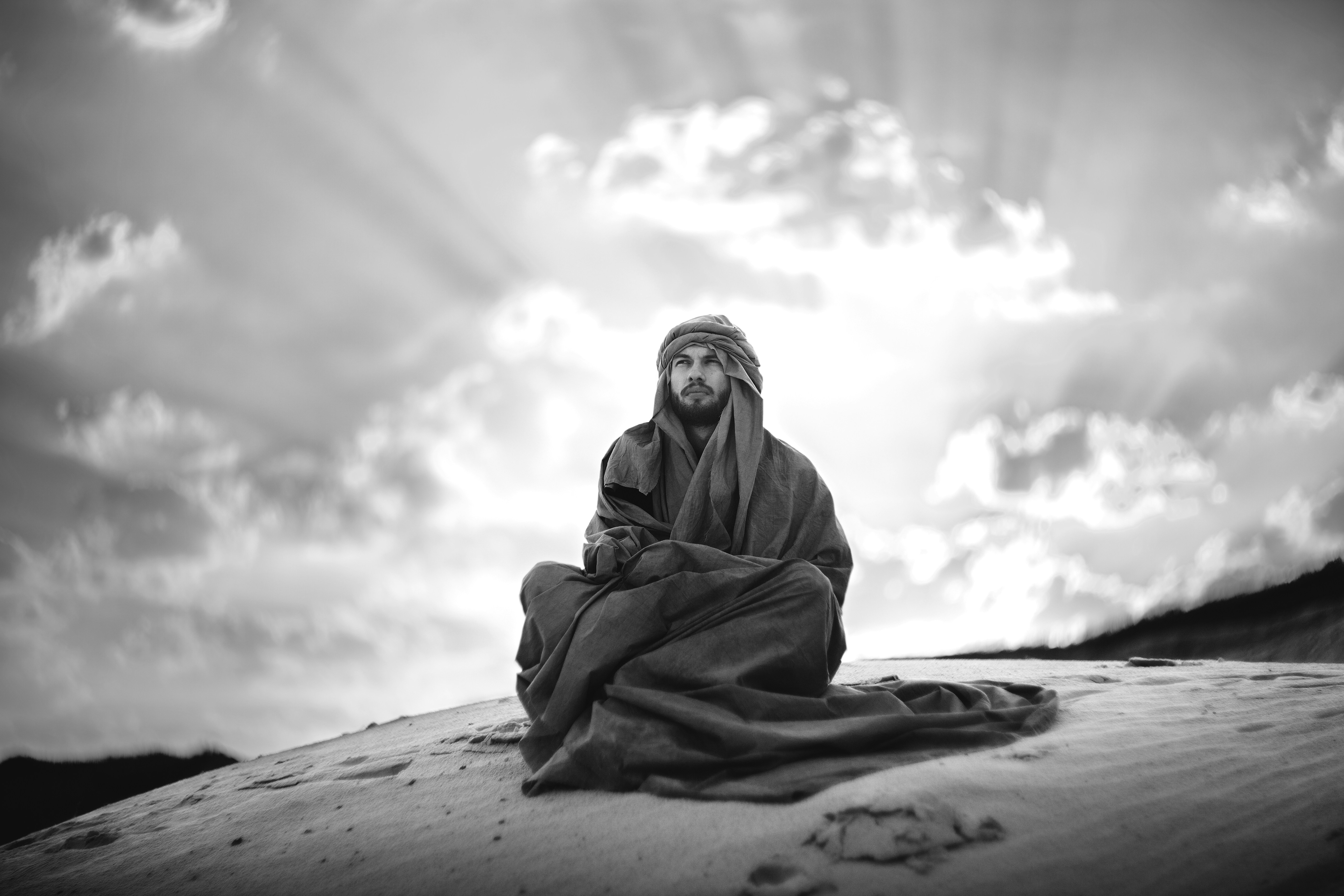 Desert Sage: A Lone Seated Figure Embraced by Light