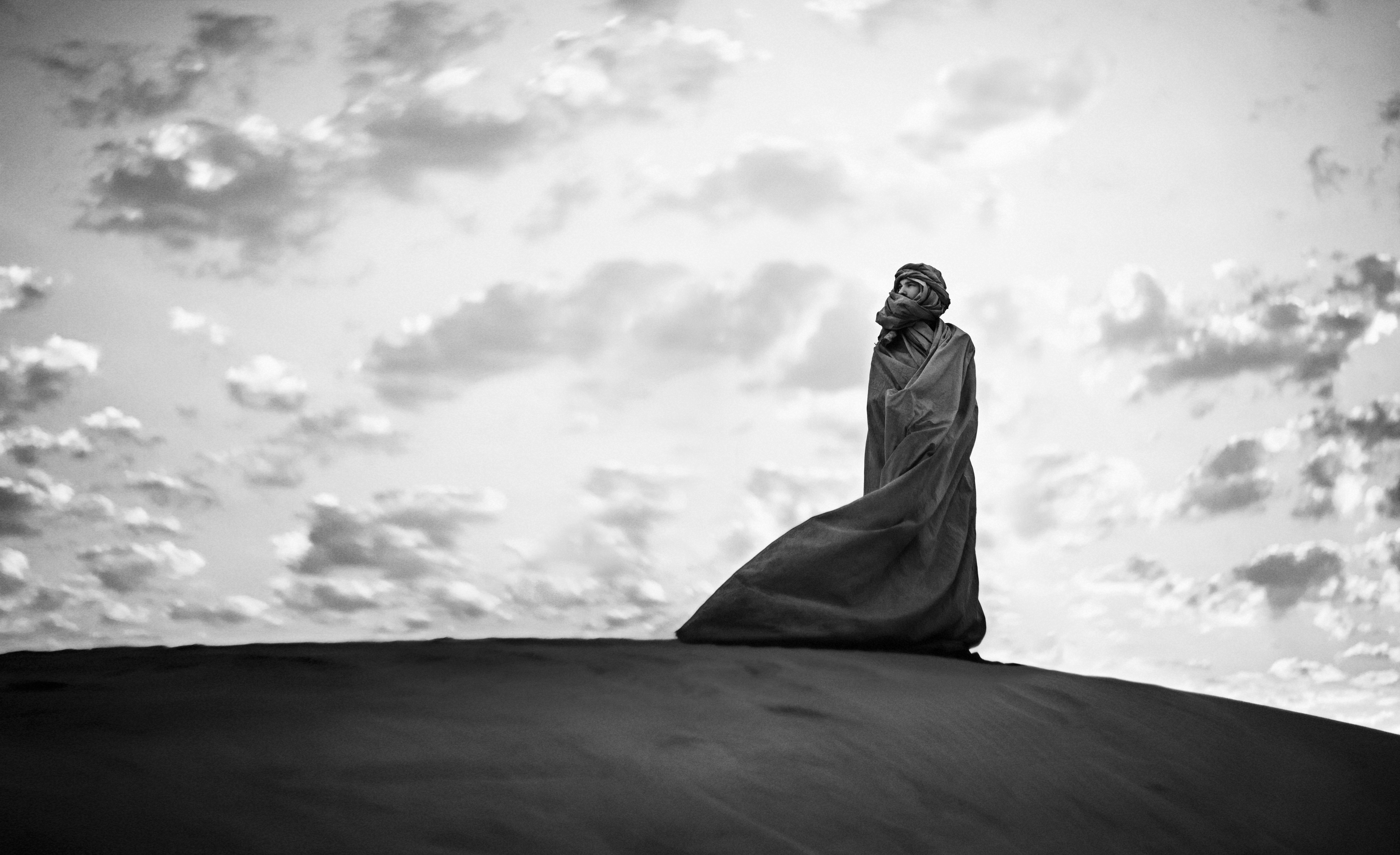 Draped Figure on a Dune Under A Vast Sky